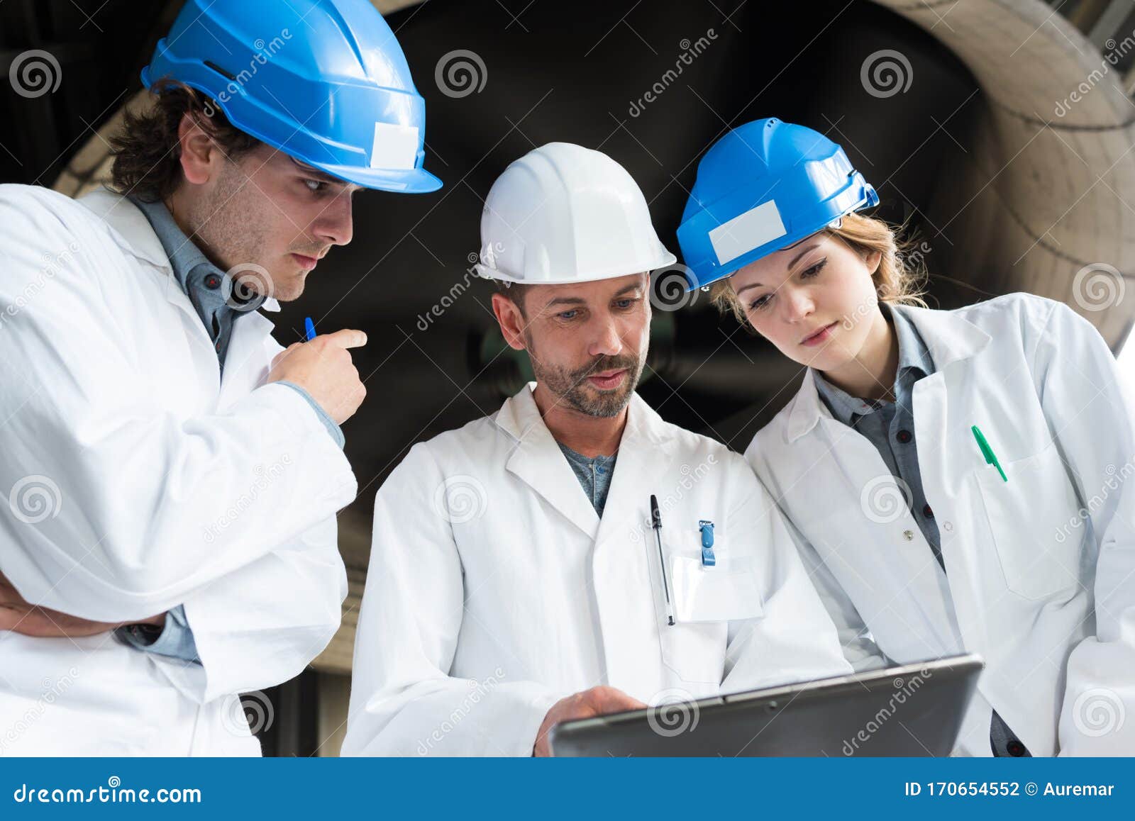 Three Industrial Engineers Looking at Laptop Stock Photo - Image of ...