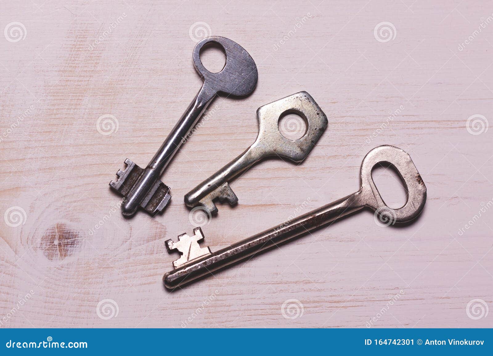 Three Iron Key Lies on a White Wooden Surface Stock Image - Image of ...