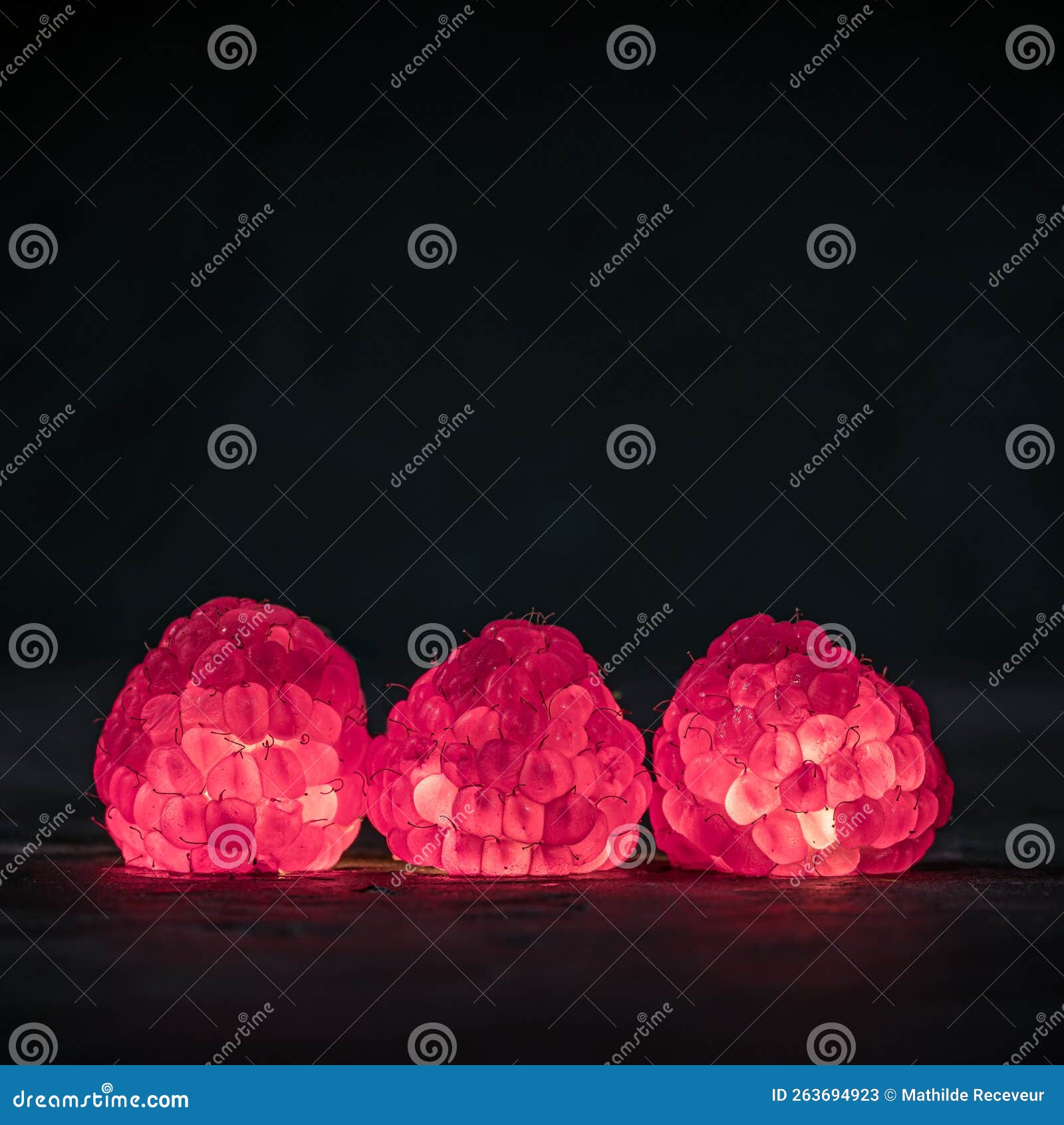 Three Isolated Illuminated Raspberry on Dark Slate Background. View ...