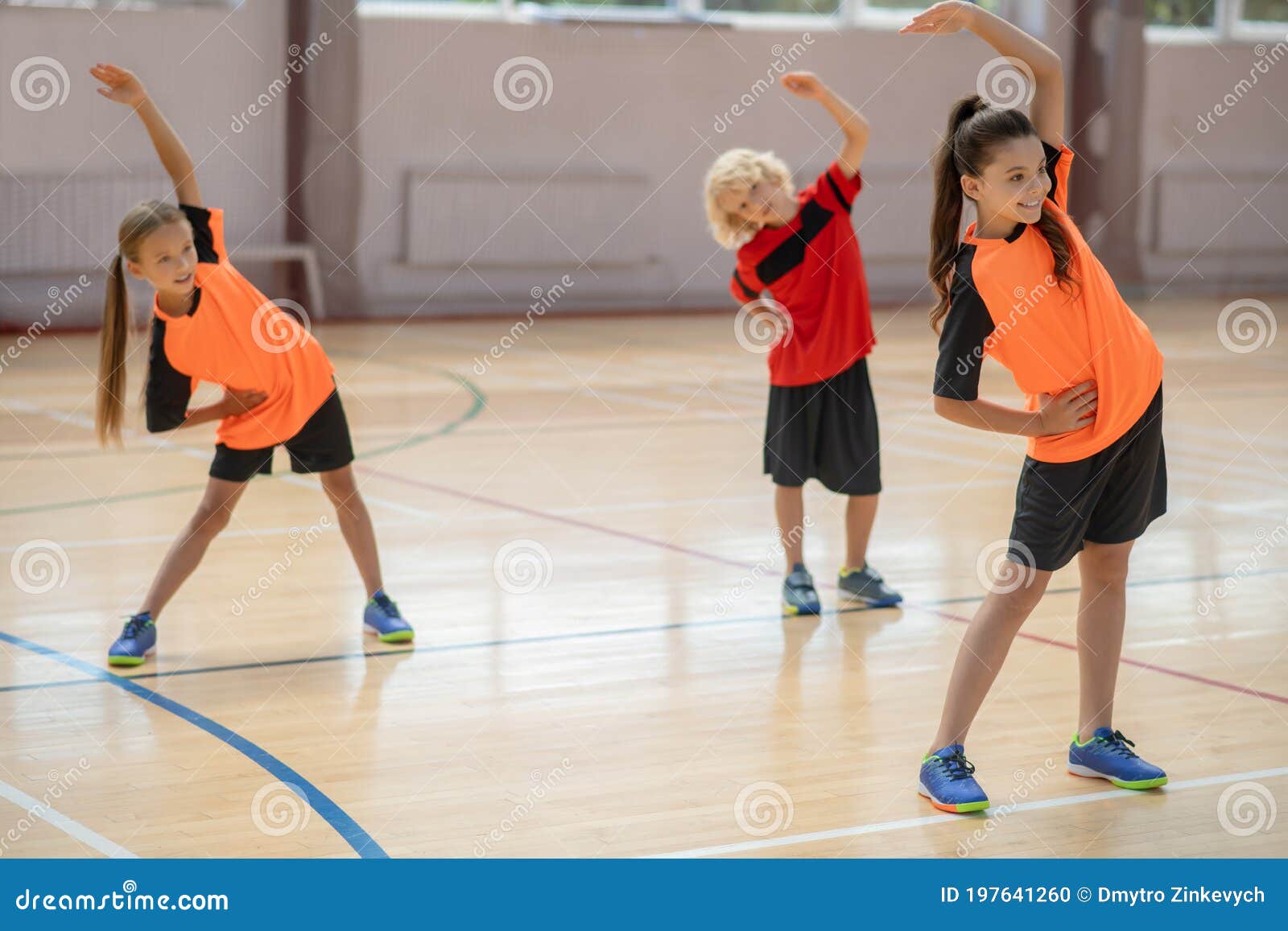 Three Kids Bending To the Right while Exercising in the Gym Stock Photo ...