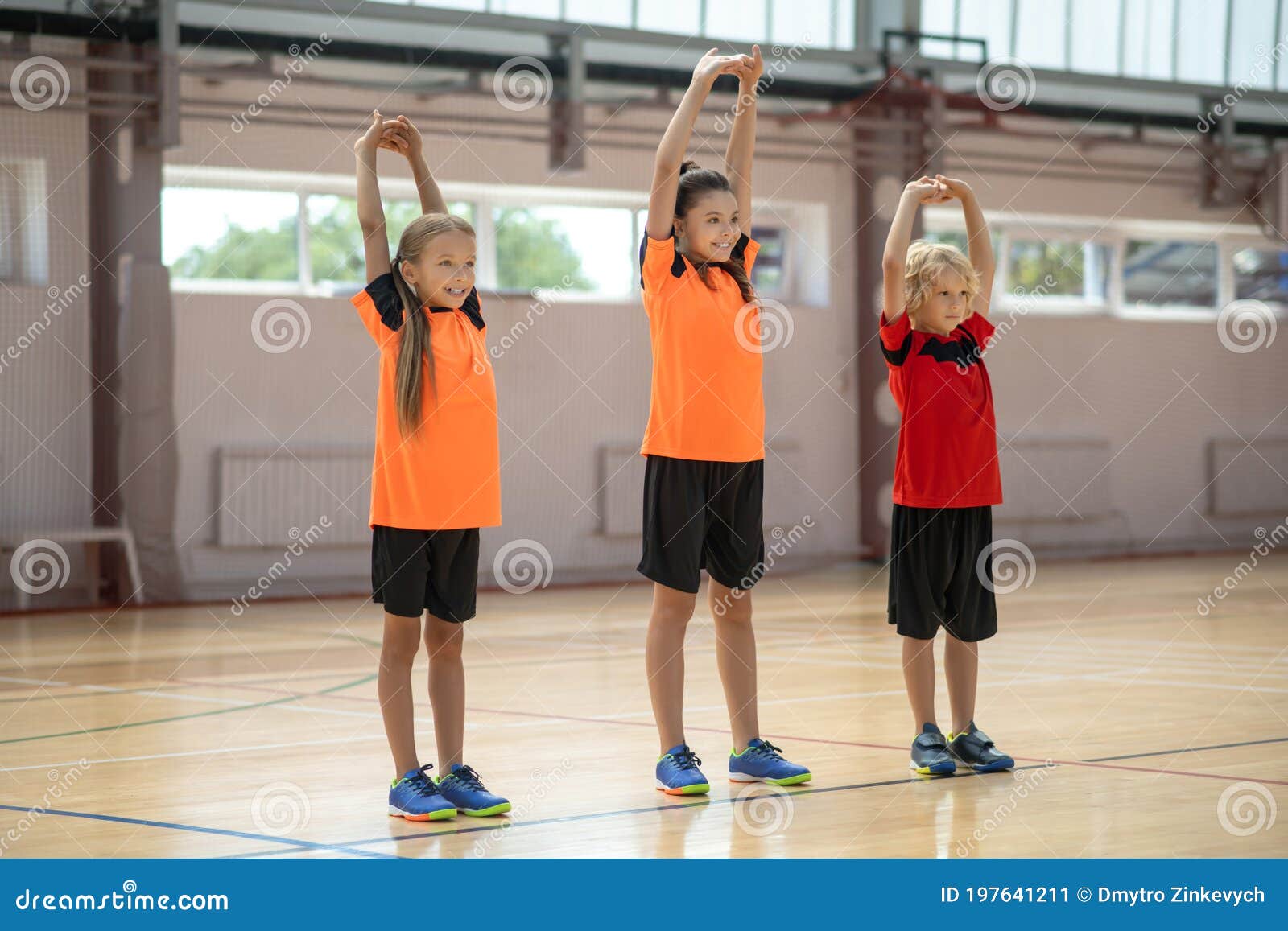 Three Kids Doing Stretching on PE Lesson Stock Image - Image of ...