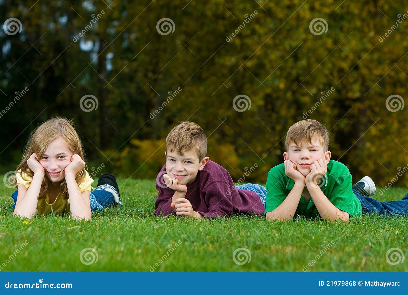 Three Kids Laying Down in the Grass Stock Photo - Image of young ...