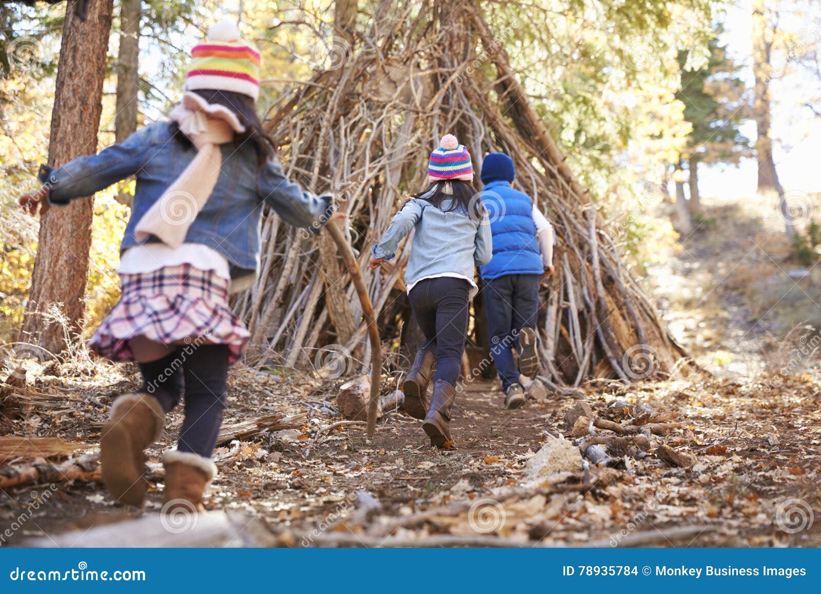 Three Kids Play Outside Shelter Made of Branches in a Forest Stock ...