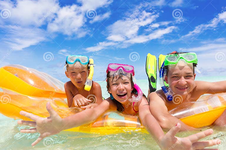 Three kids on a raft stock image. Image of ocean, masks - 16578201