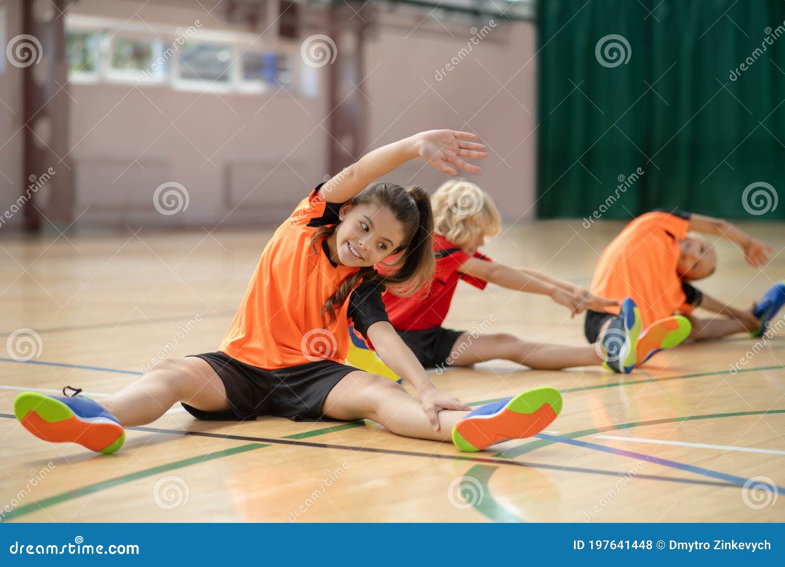 Three Kids Sitting on the Floor and Stretching To the Left Stock Photo ...