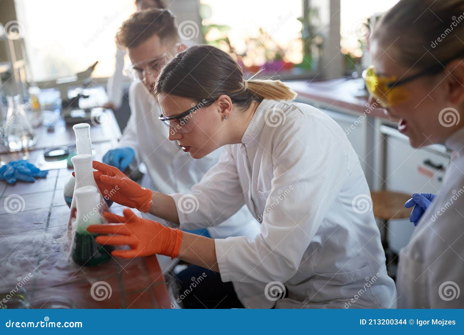 Three Laborant Technicians Examining Chemical Reactions Stock Photo ...