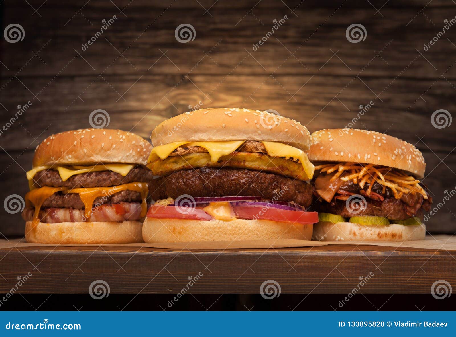 Three Large Burgers on Wooden Background. Low Angle Front View. Copy ...