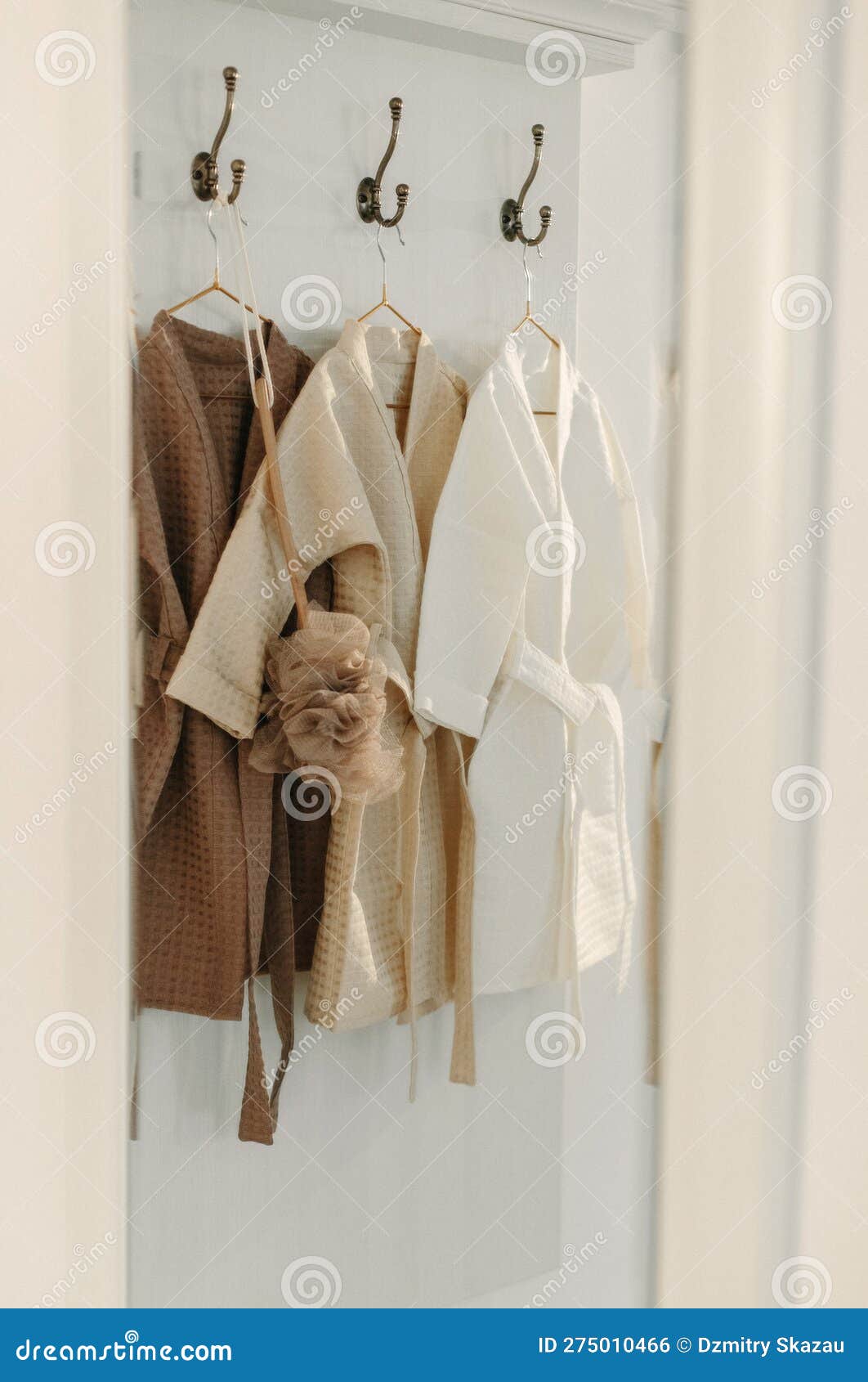 Three Linen Robes of Different Colors Hang on a Hanger in the Bathroom ...
