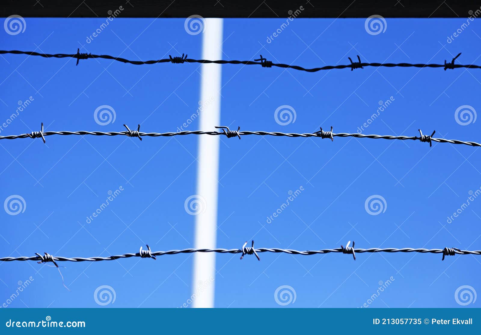 Three Lines of Barbed Wire Against a Blue Background Stock Image ...