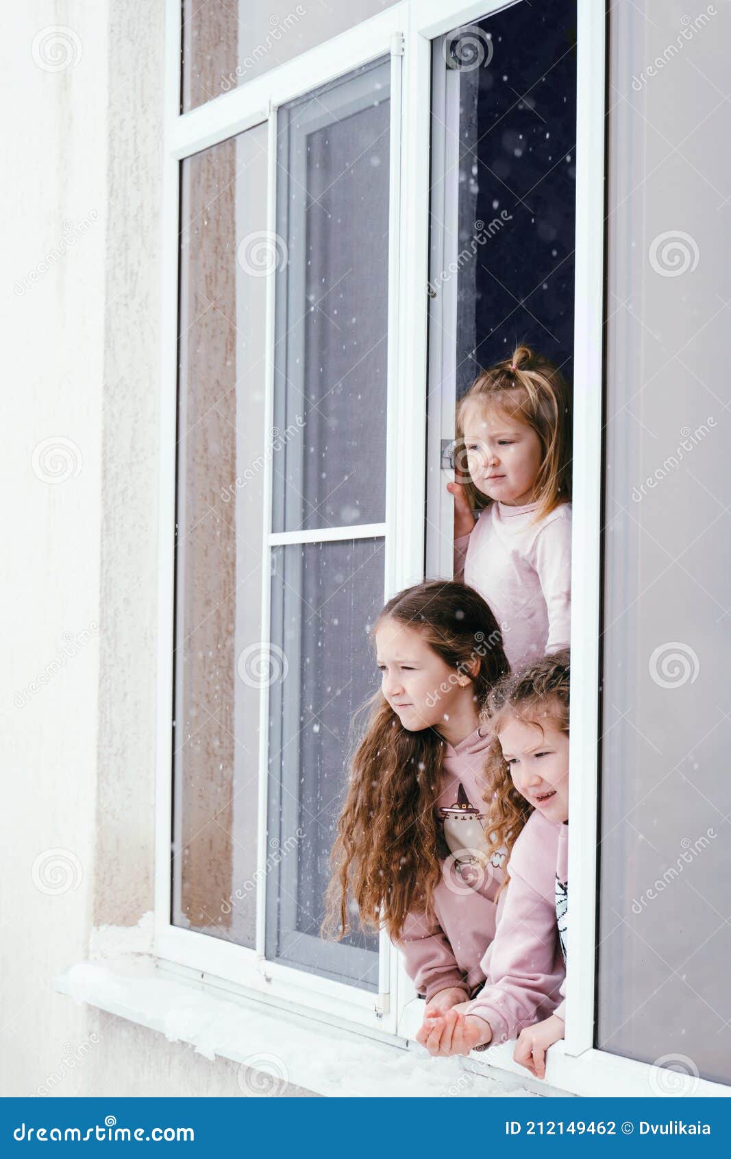 Little Girls Lean Out of the Window and Look at the Falling Snow Stock ...