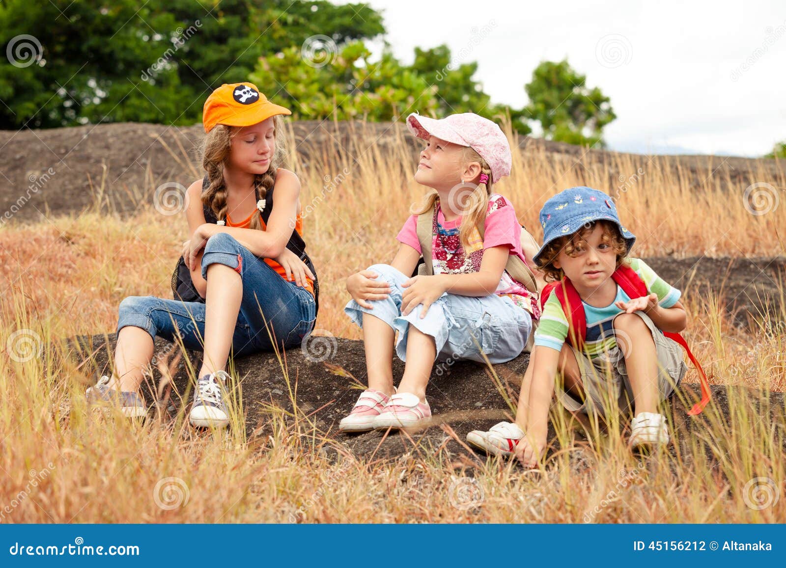 Three Little Kids with Backpack Sitting on the Footpath in the M Stock ...