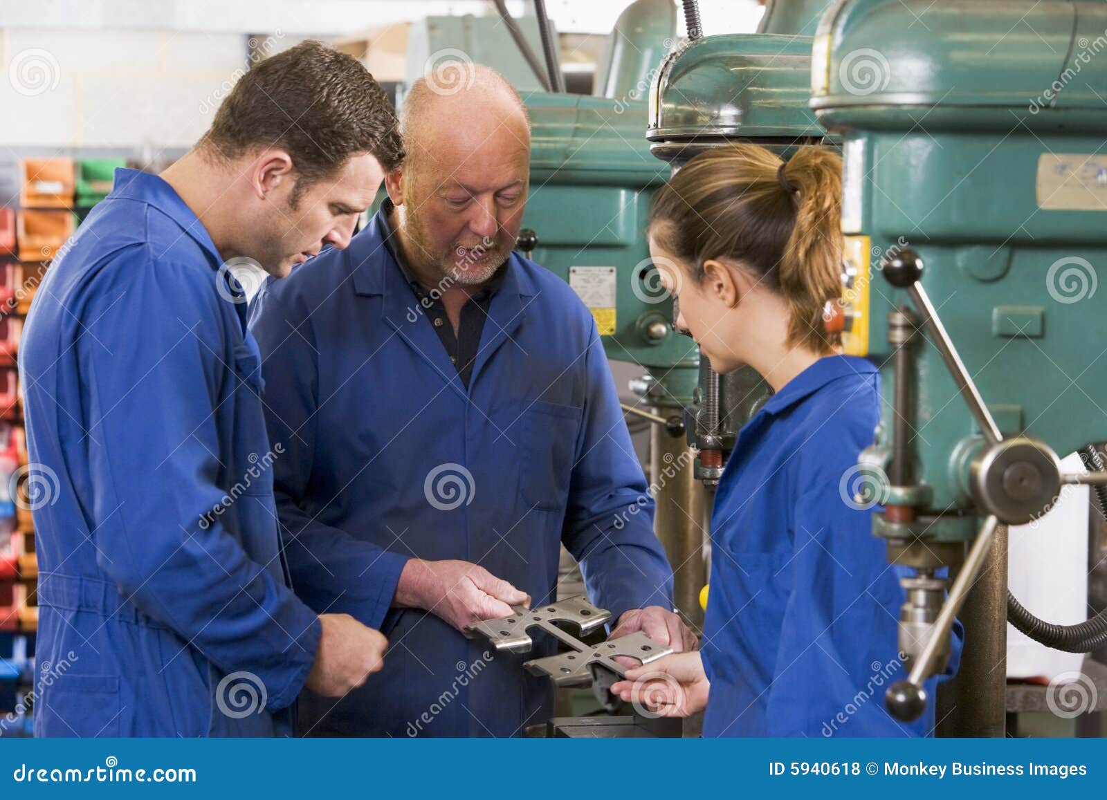 Three Machinists in Workspace by Machine Talking Stock Photo - Image of ...