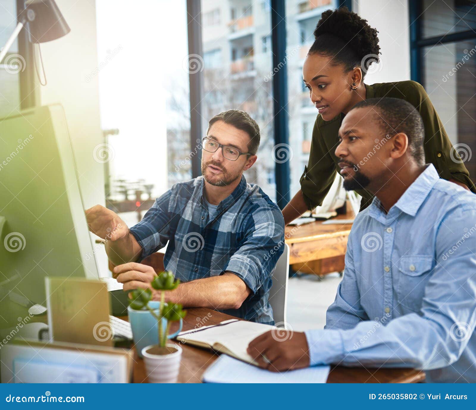 Three Makes a Team. Three Businesspeople Working Around a Computer in ...