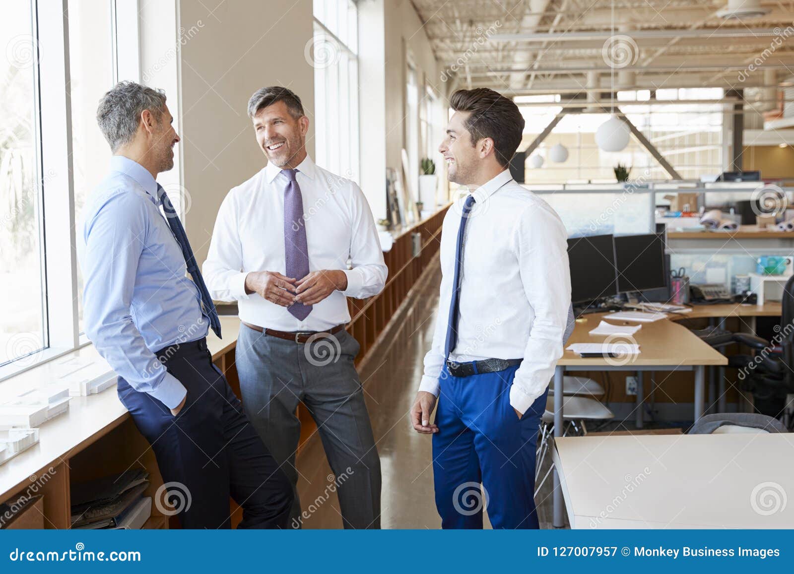 Three Male Corporate Business Colleagues Chatting at Work Stock Image ...
