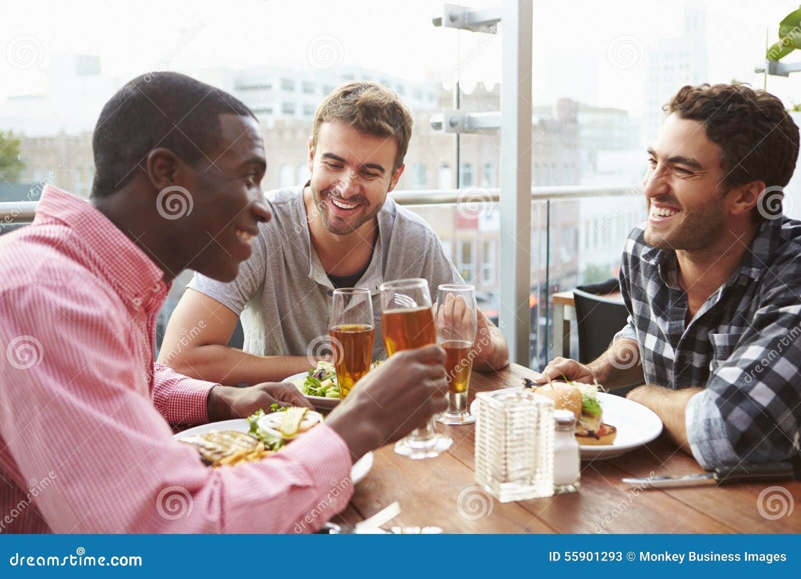 Three Male Friends Enjoying Lunch at Rooftop Restaurant Stock Image ...