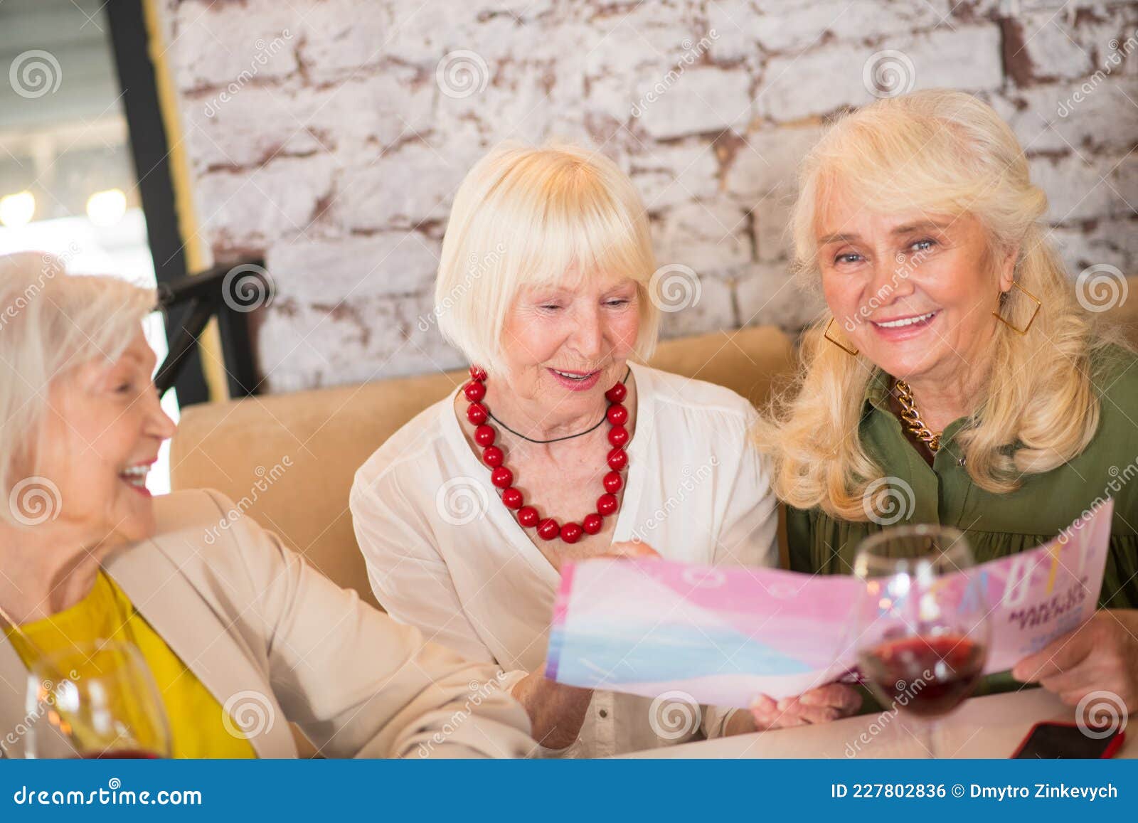 Three Mature Women Sitting at the Table and Looking Excited Stock Photo ...