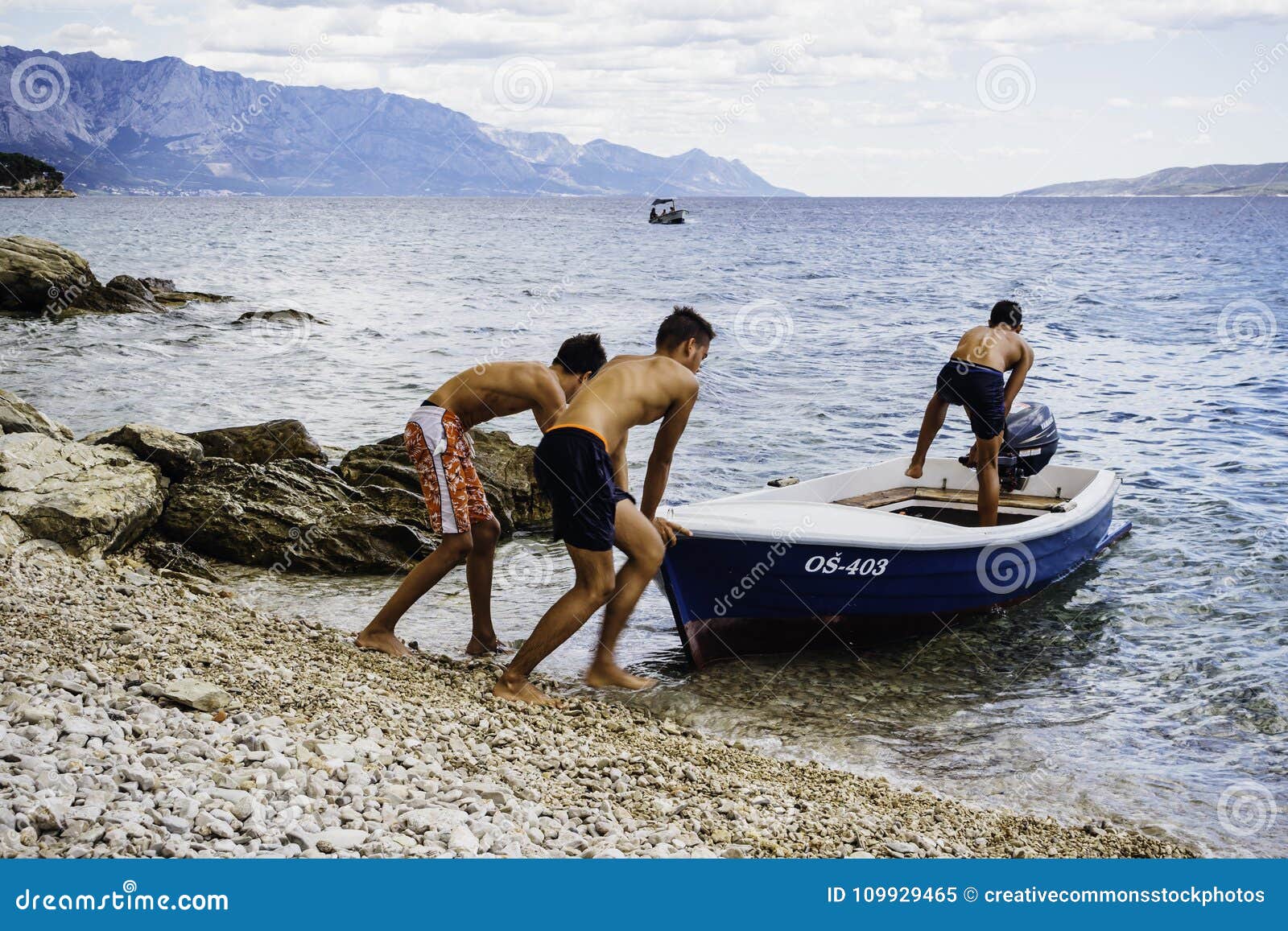 Three Men Pushing Speed Boat On Seashore Picture. Image: 109929465