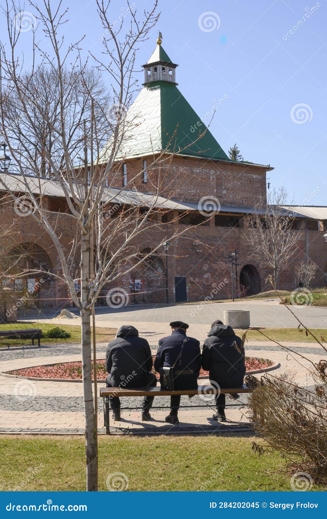 Three Men Sit on a Bench in Spring Inside the Ancient Fortress of the ...