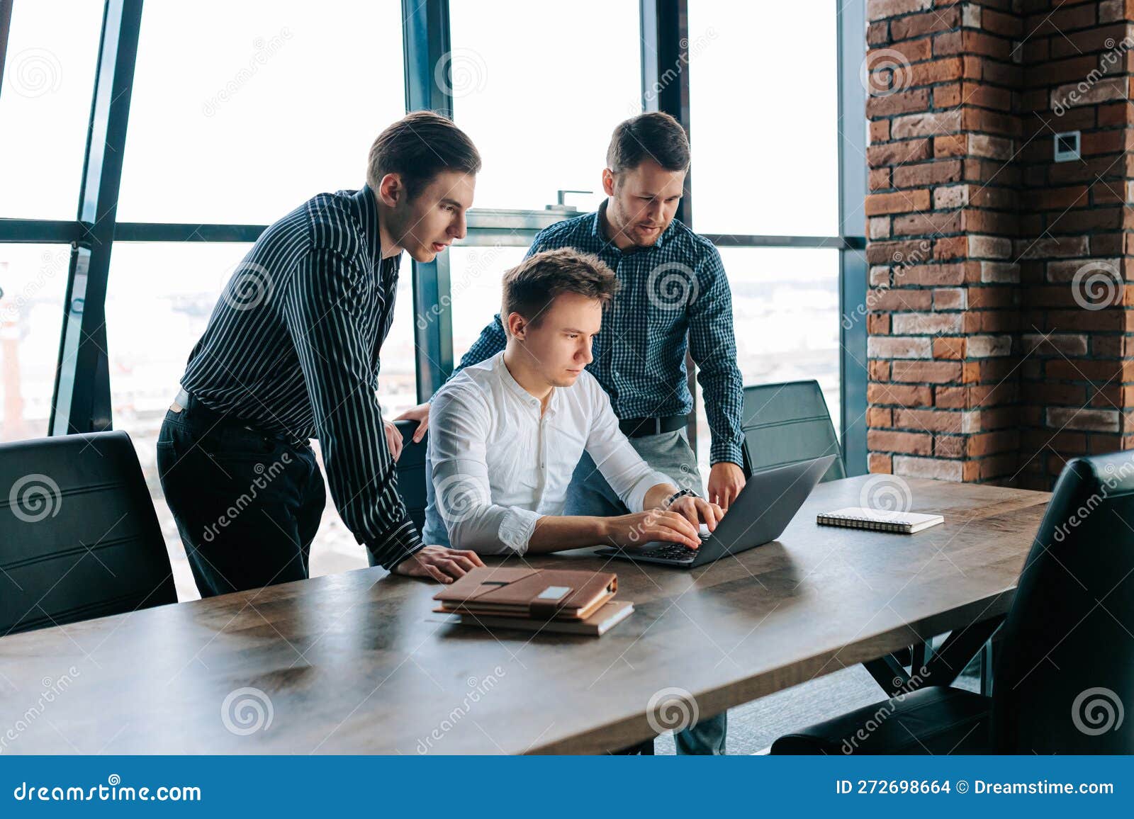 Three Men Working Together on Laptops in a Modern Office Space. Stock ...