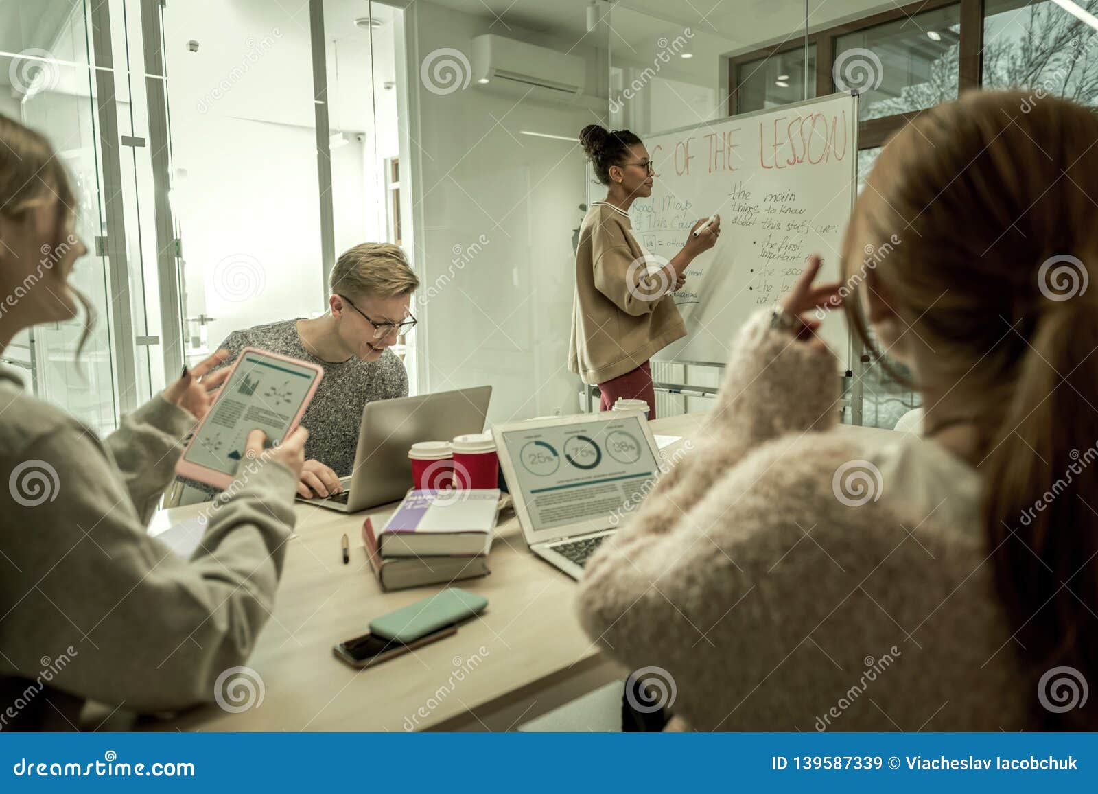 Three Modern Students Using Their Gadgets during the Class Stock Image ...