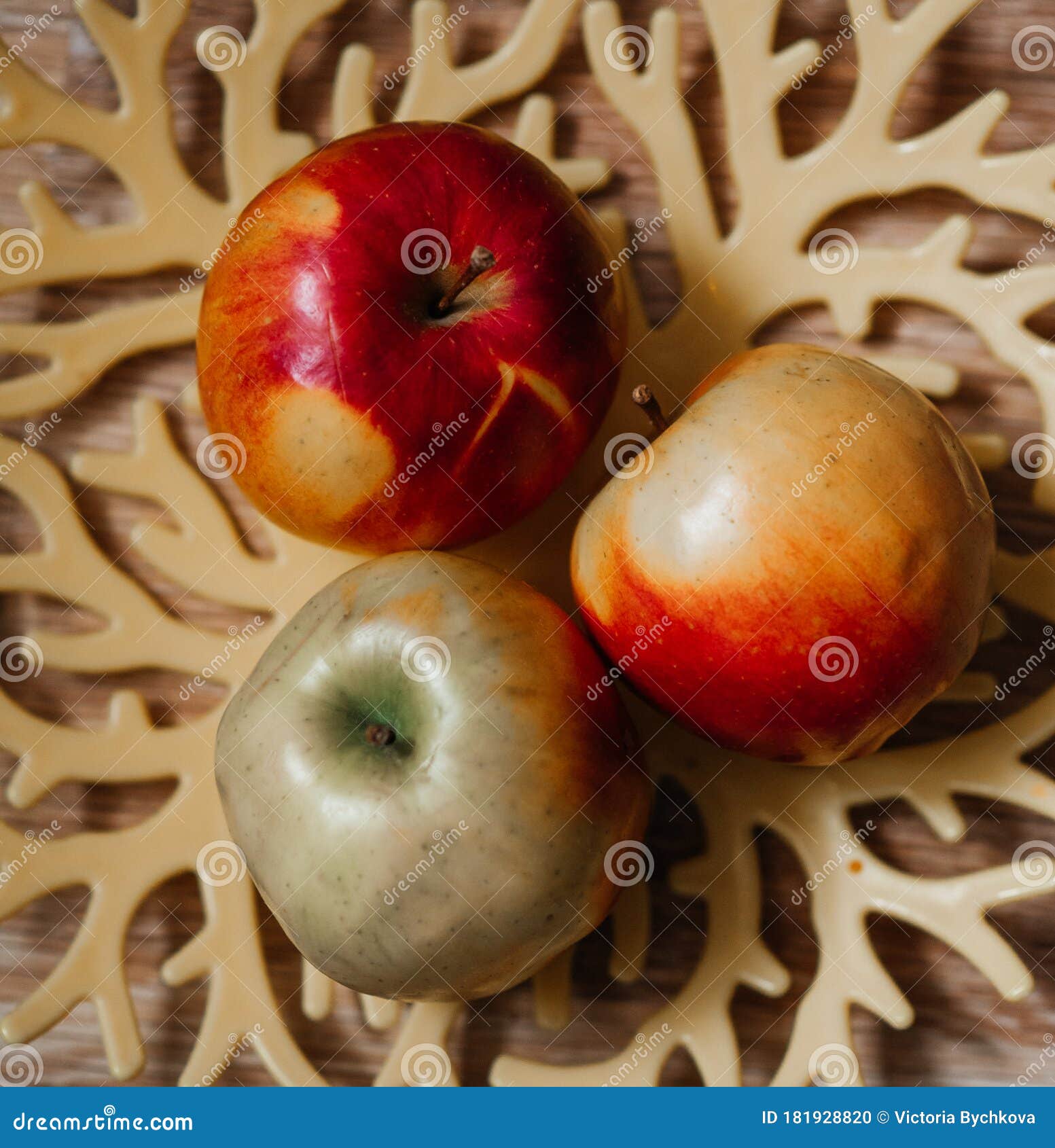 .three Multi-colored Apples on a Yellow Plate on a Wooden Background ...