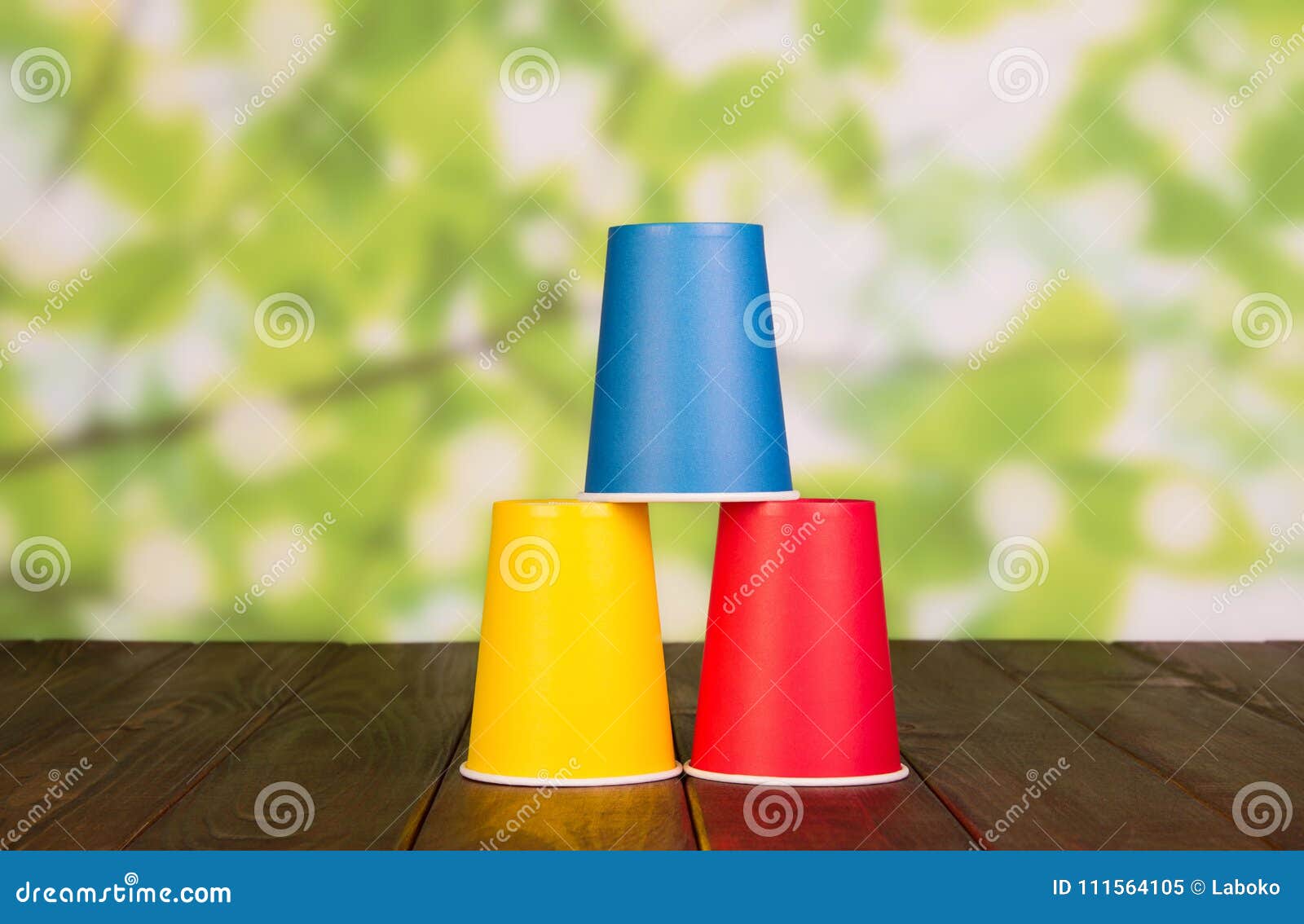 Three Multi-colored Plastic Cups Stand on Each Other, on Wooden Table ...