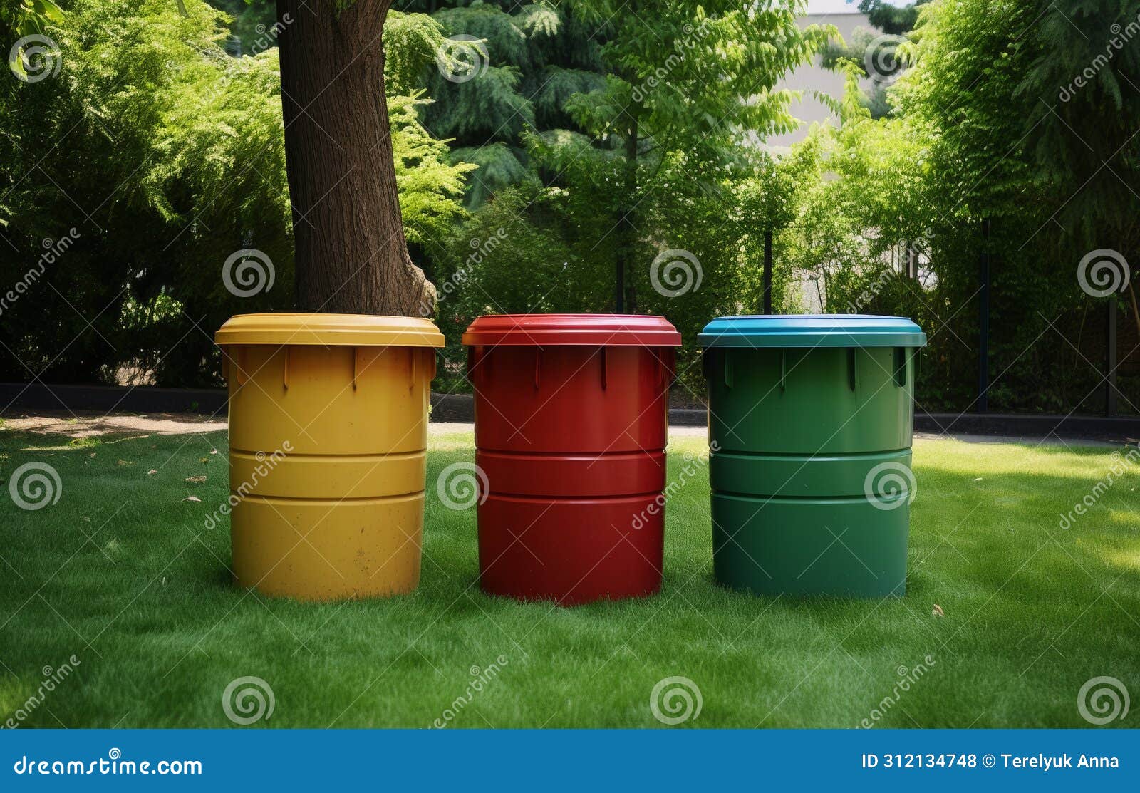Three Multi Colored Plastic Garbage Cans Stand on the Green Grass in ...