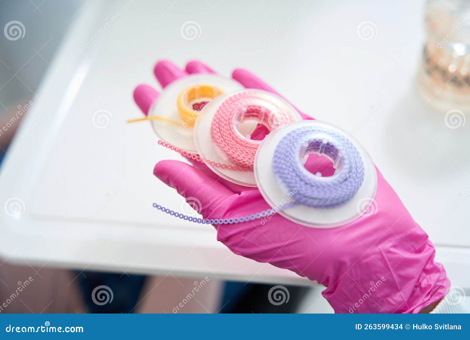 Three Multi-colored Spools of Consumables Lie in Palm of Orthodontist ...