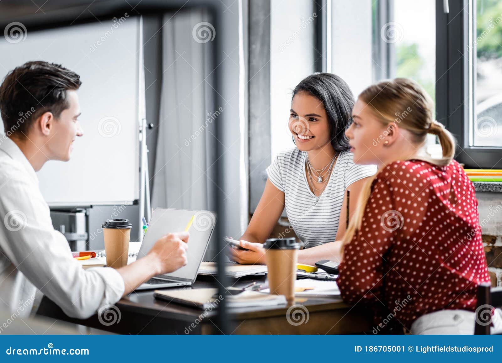 Multiethnic Friends Sitting at Table and Talking in Apartment Stock ...