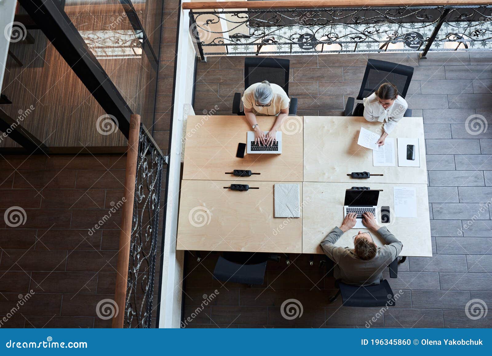 Three Office Workers Sitting at a Desk Working Hard Stock Photo - Image ...