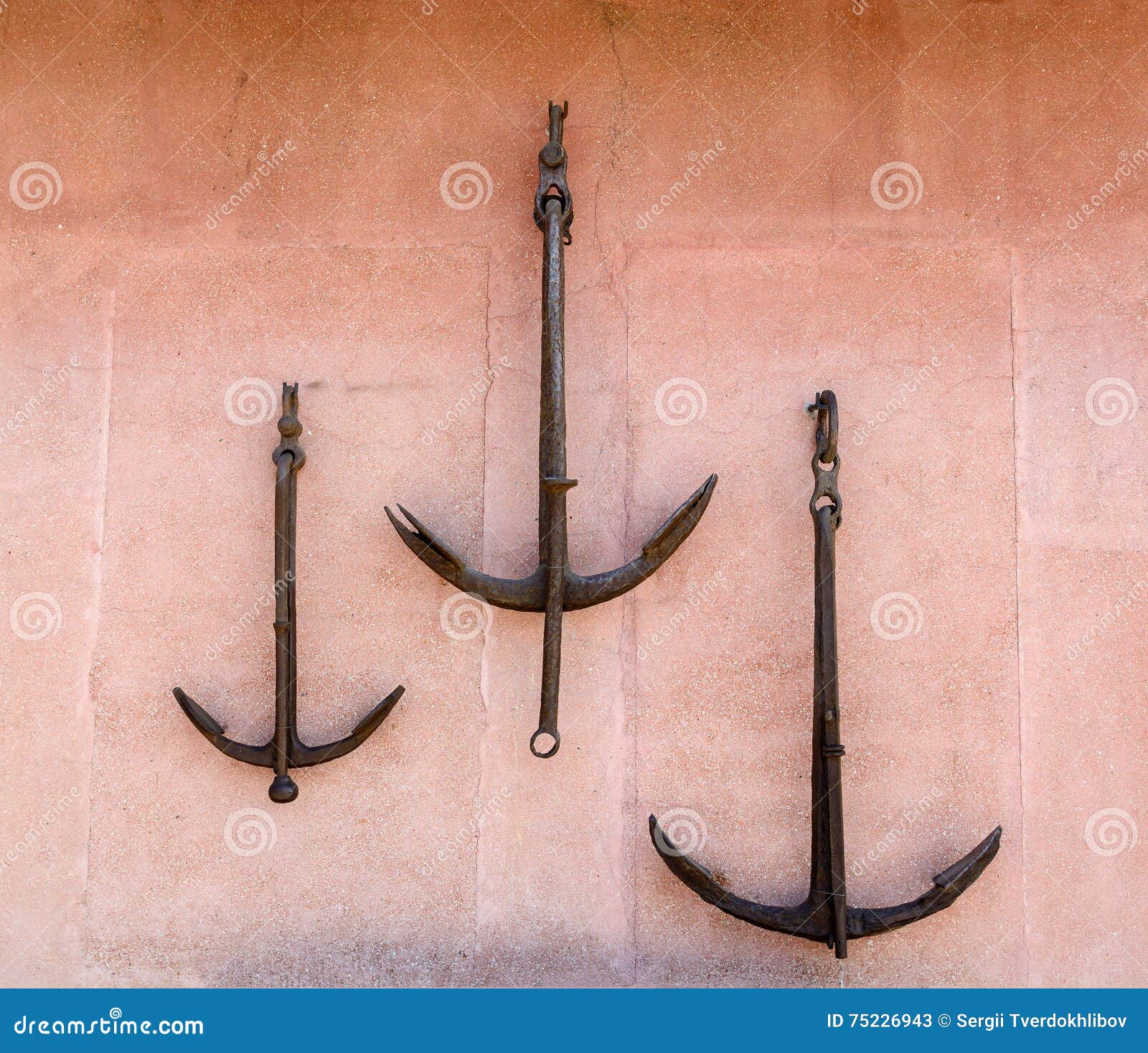 Three Old Rusty Anchor Hanging on the Plastered Wall Burgundy Stock ...