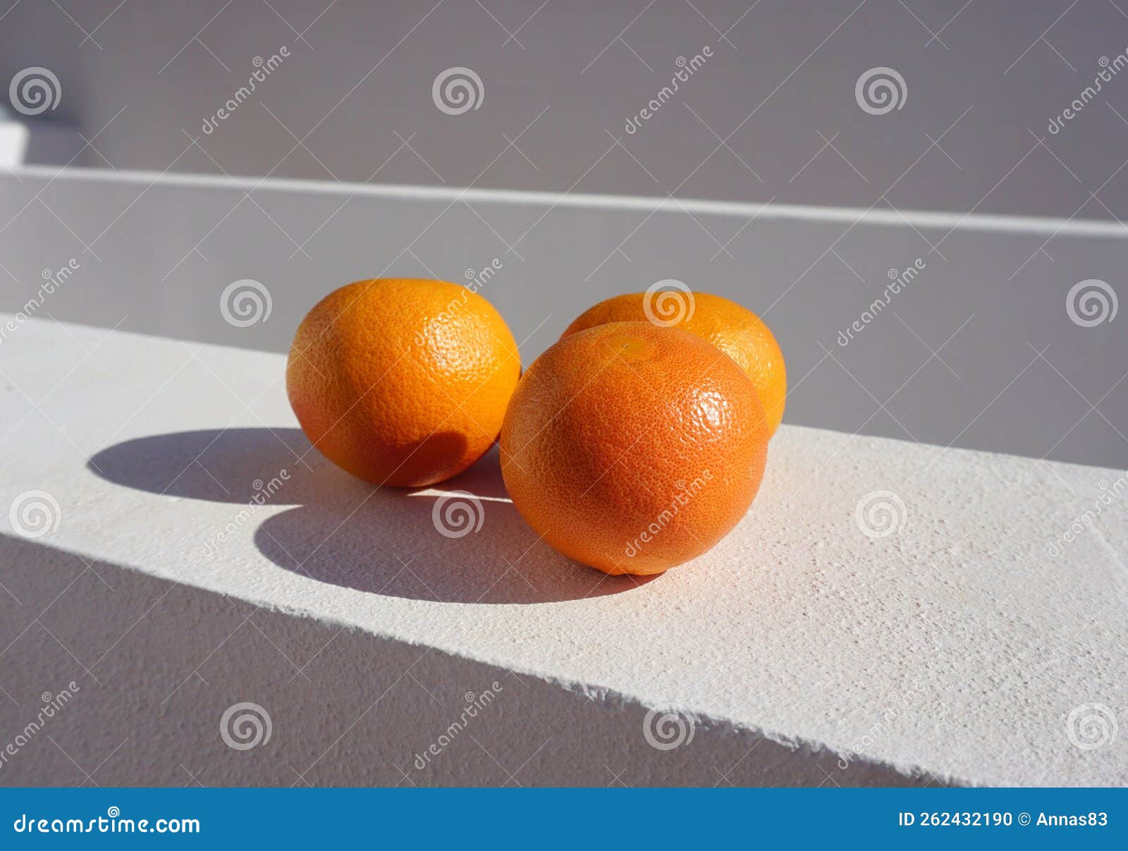 Three Oranges Isolated Close-up in the Sun Lying on the White Surface ...