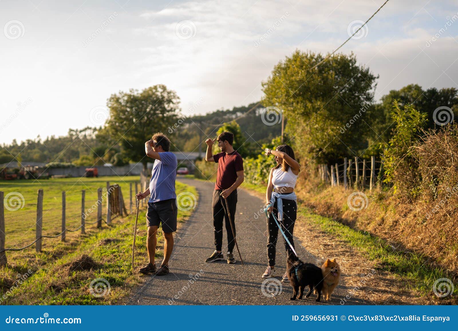 Three People Observing the Landscape in the Nature at Sunset with Two ...
