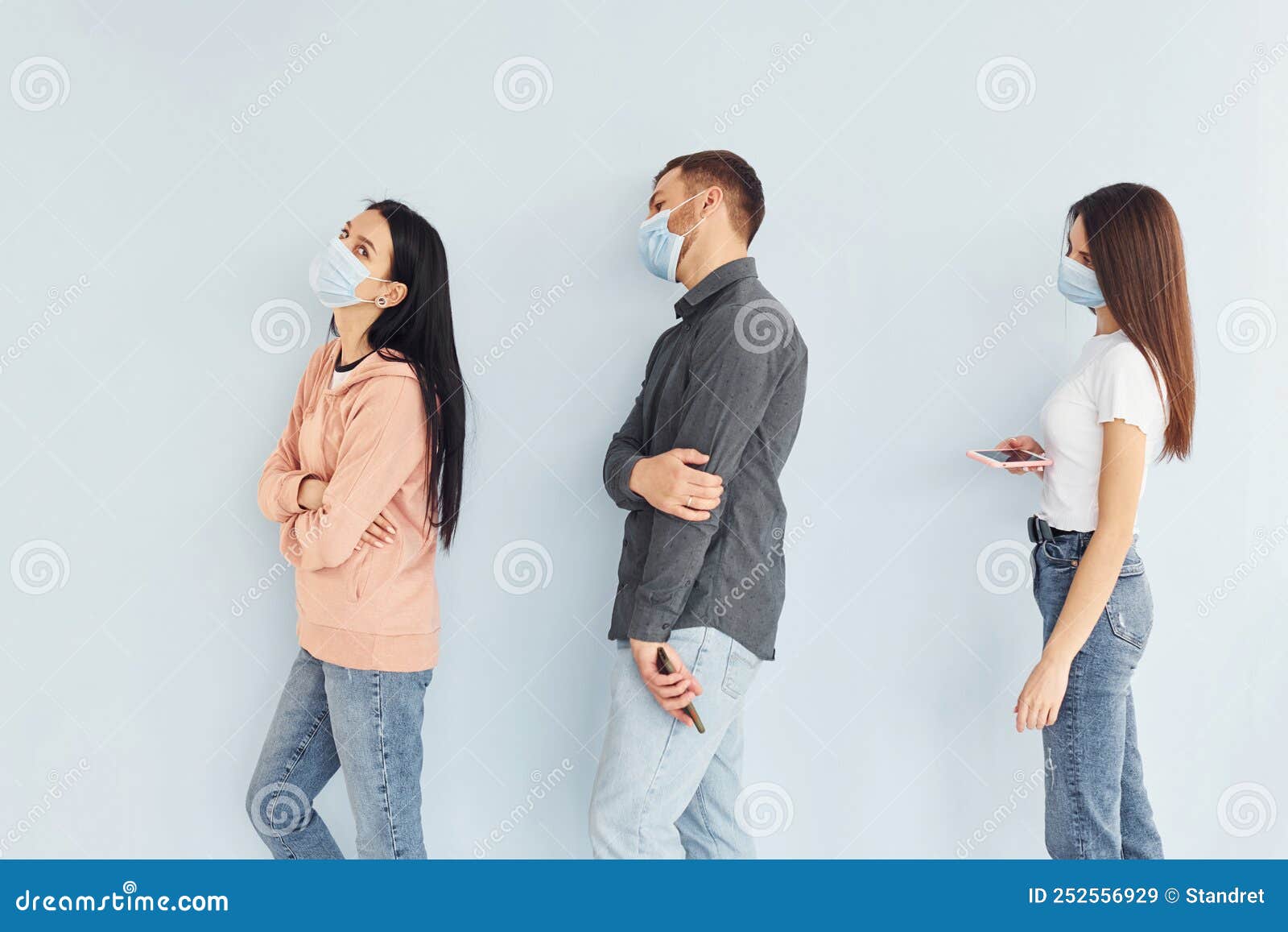 Three People Standing Together in the Studio Against White Background ...