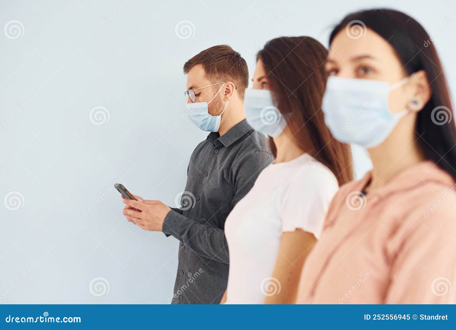 Three People Standing Together in the Studio Against White Background ...