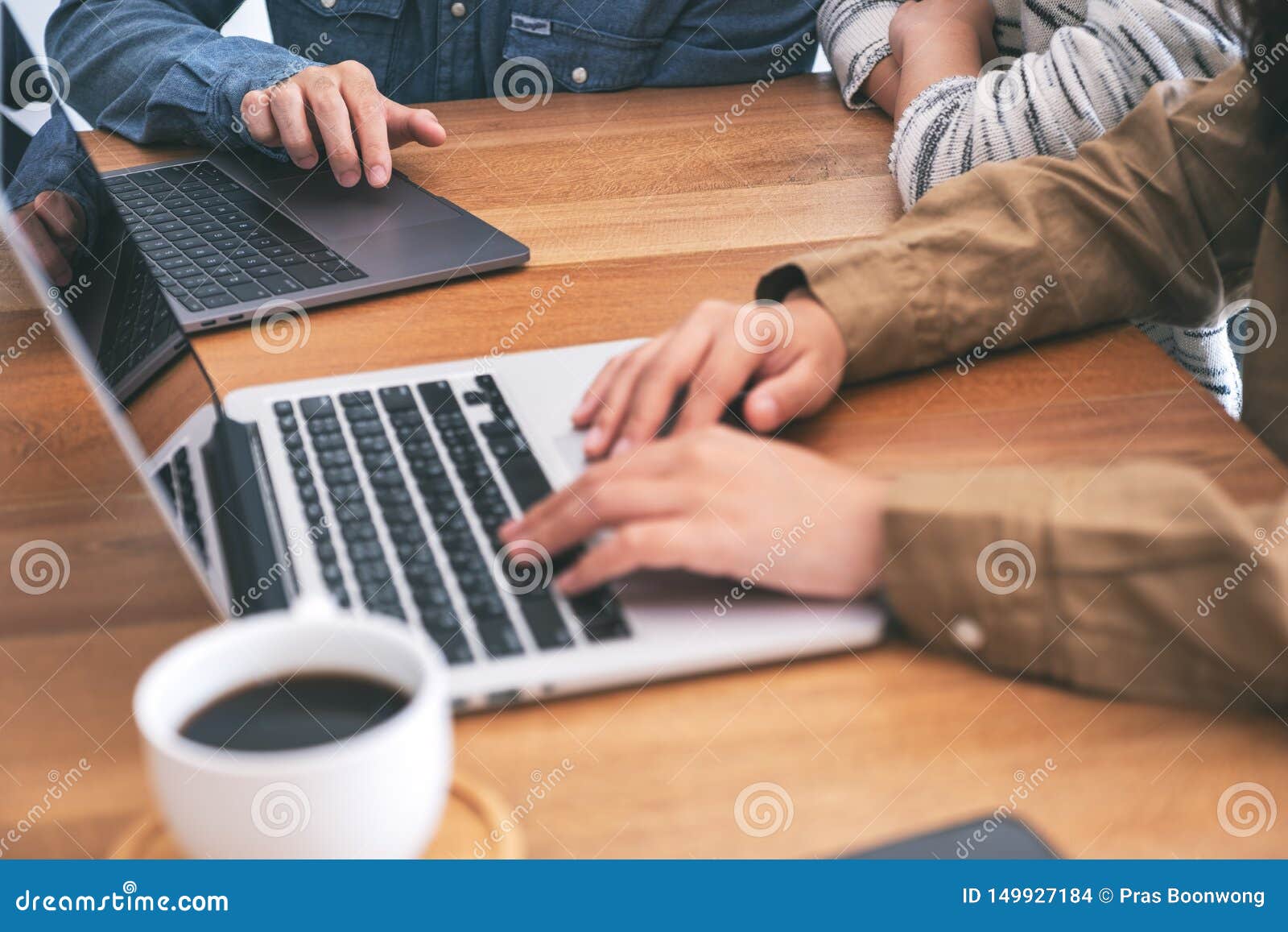 Three People Using and Typing on Laptop Computer on Wooden Table Stock ...