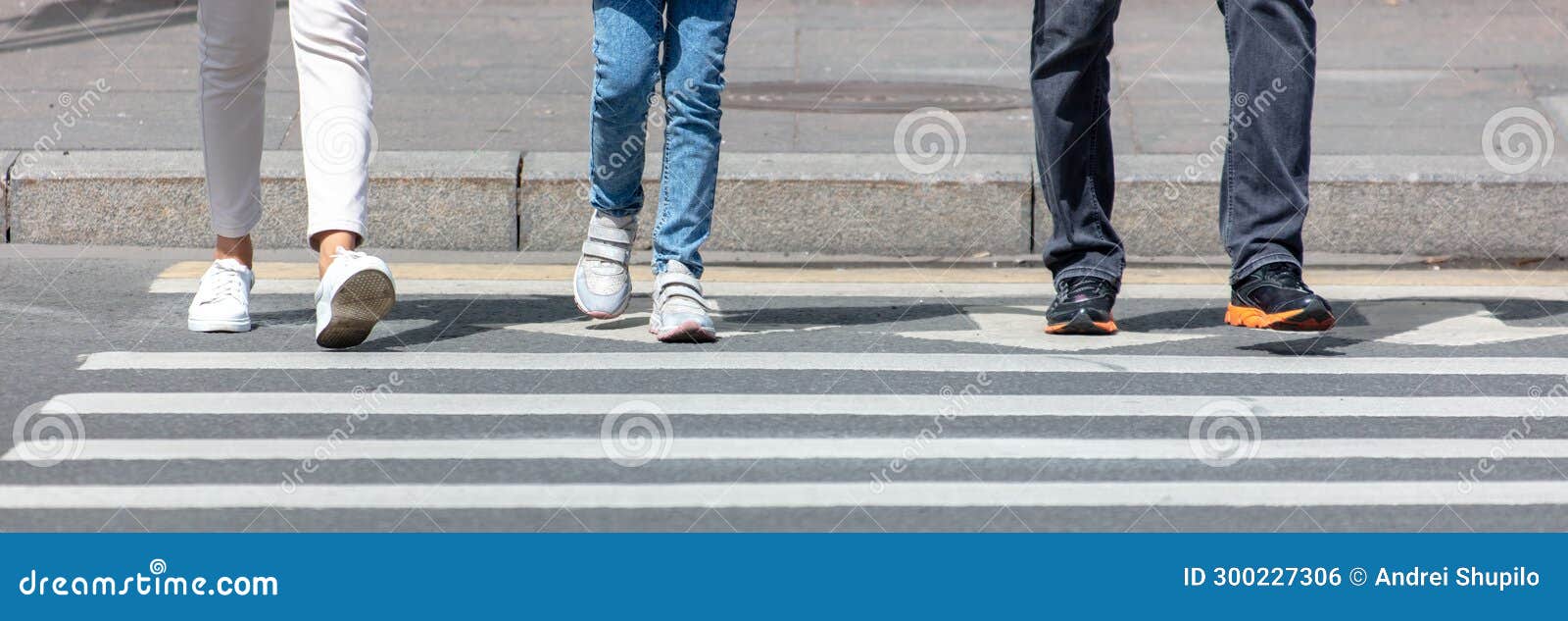 Three People are Walking Along a Pedestrian Crossing Stock Photo ...