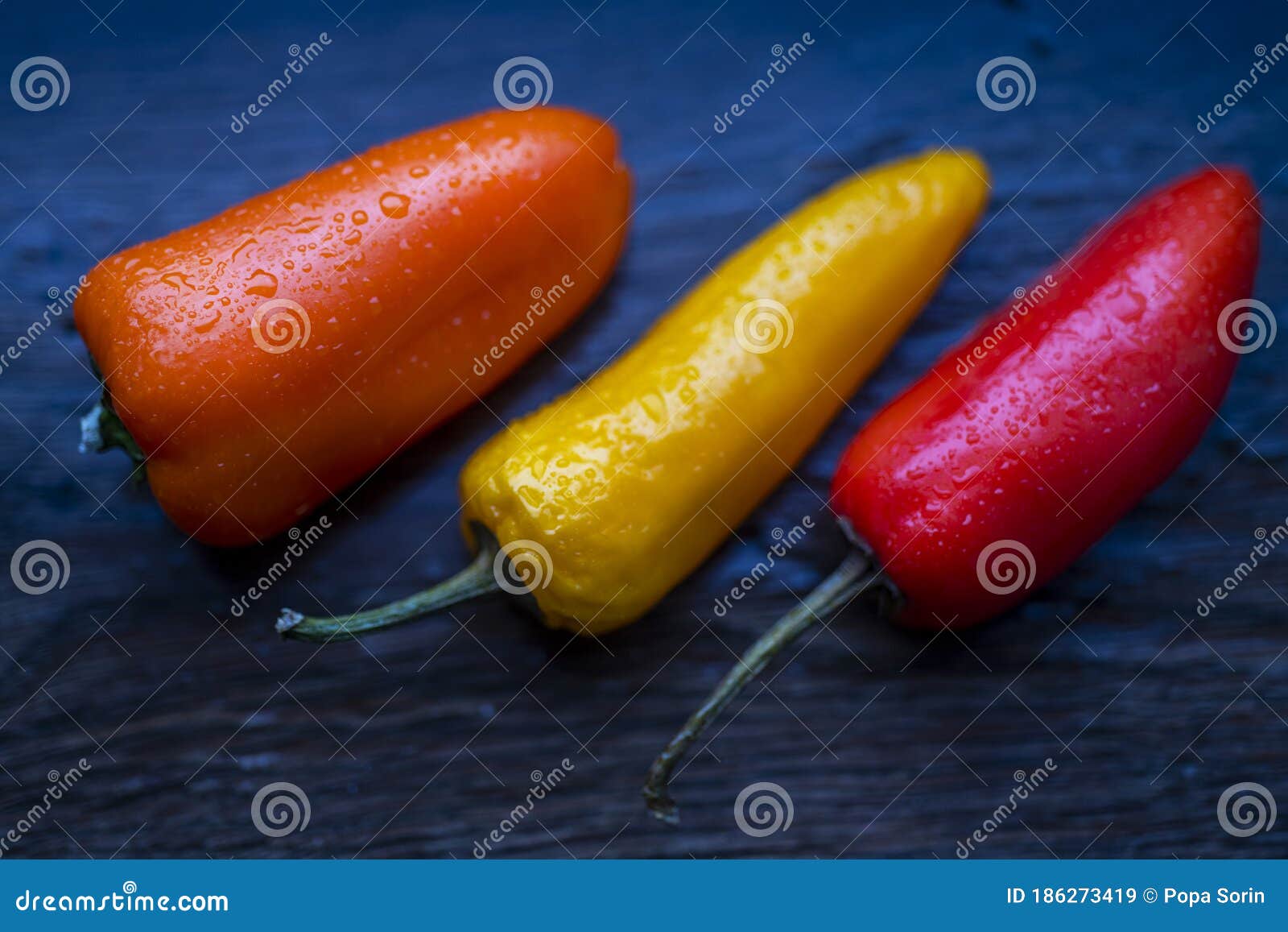Three Peppers Over a Blue Background Stock Image - Image of ingredient ...