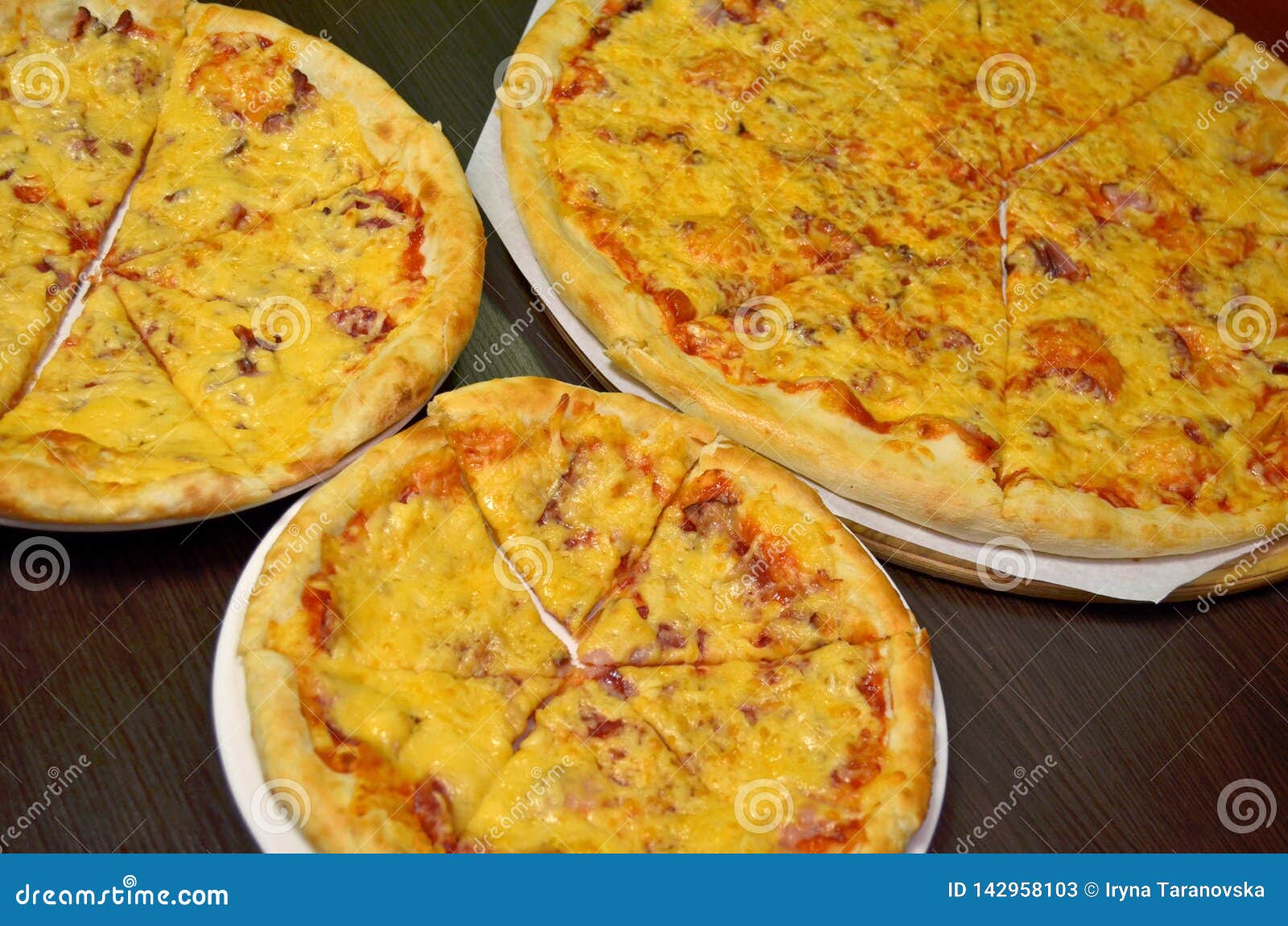 Three Pizzas with Cheese and Meat of Different Sizes on a Dark ...