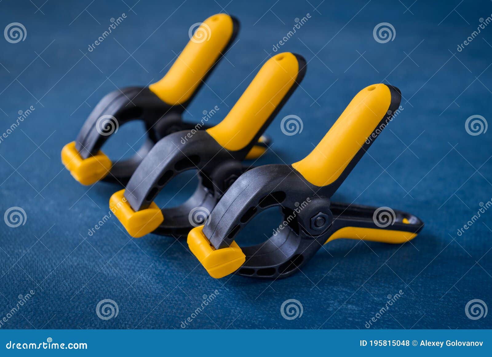 Three Plastic Spring Clips on Blue Background, Closeup Stock Photo ...
