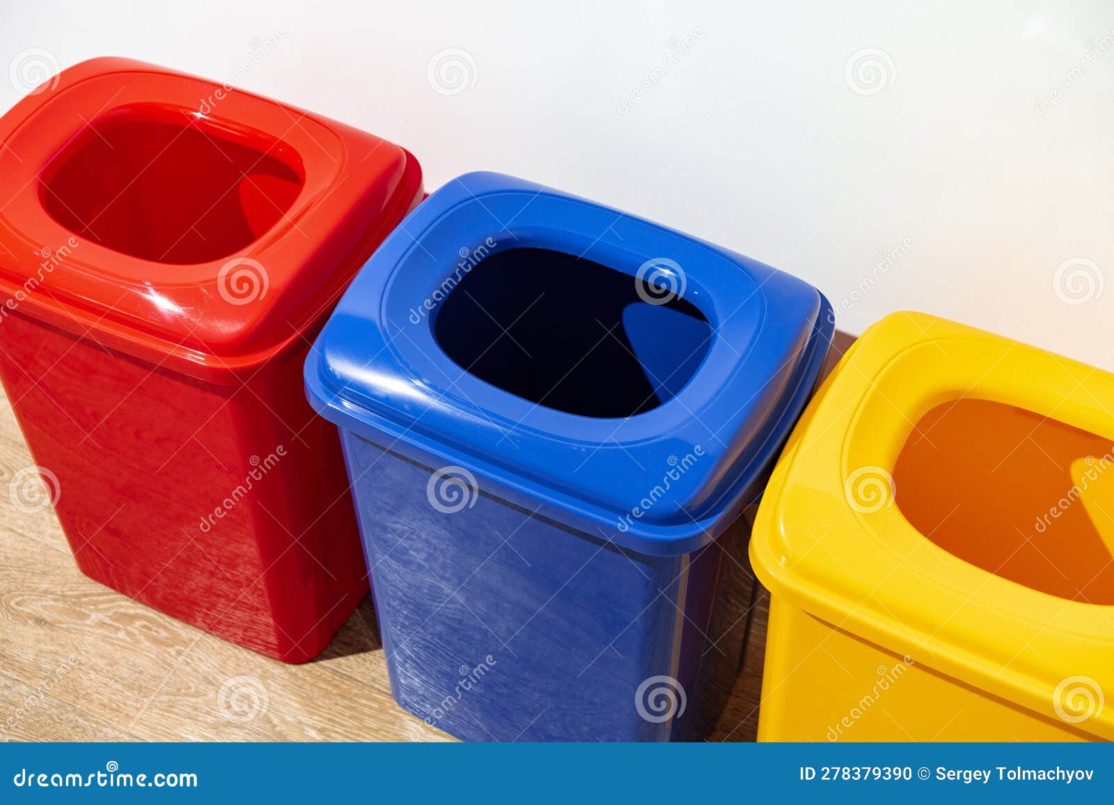 Three Plastic Trash Bins Against the Wall in the Building Stock Photo ...