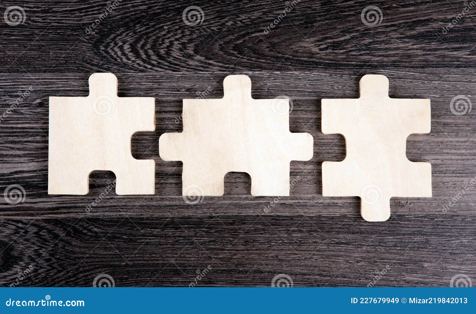 Three Puzzle Pieces in a Row on a Wooden Background Stock Image - Image ...