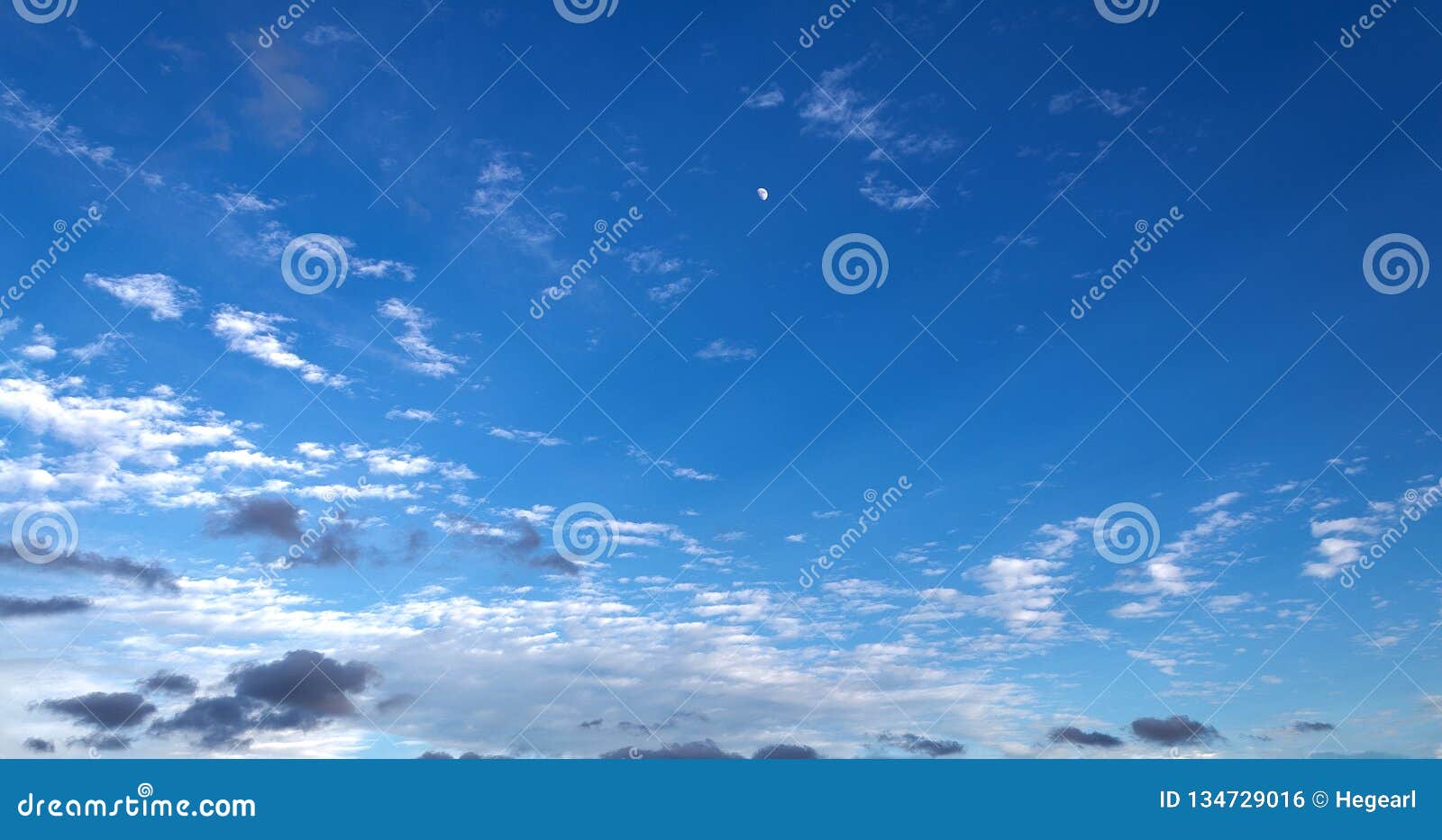 Three Quarter Moon Rising As the Sun Sets on a Dark Blue Sky Stock ...