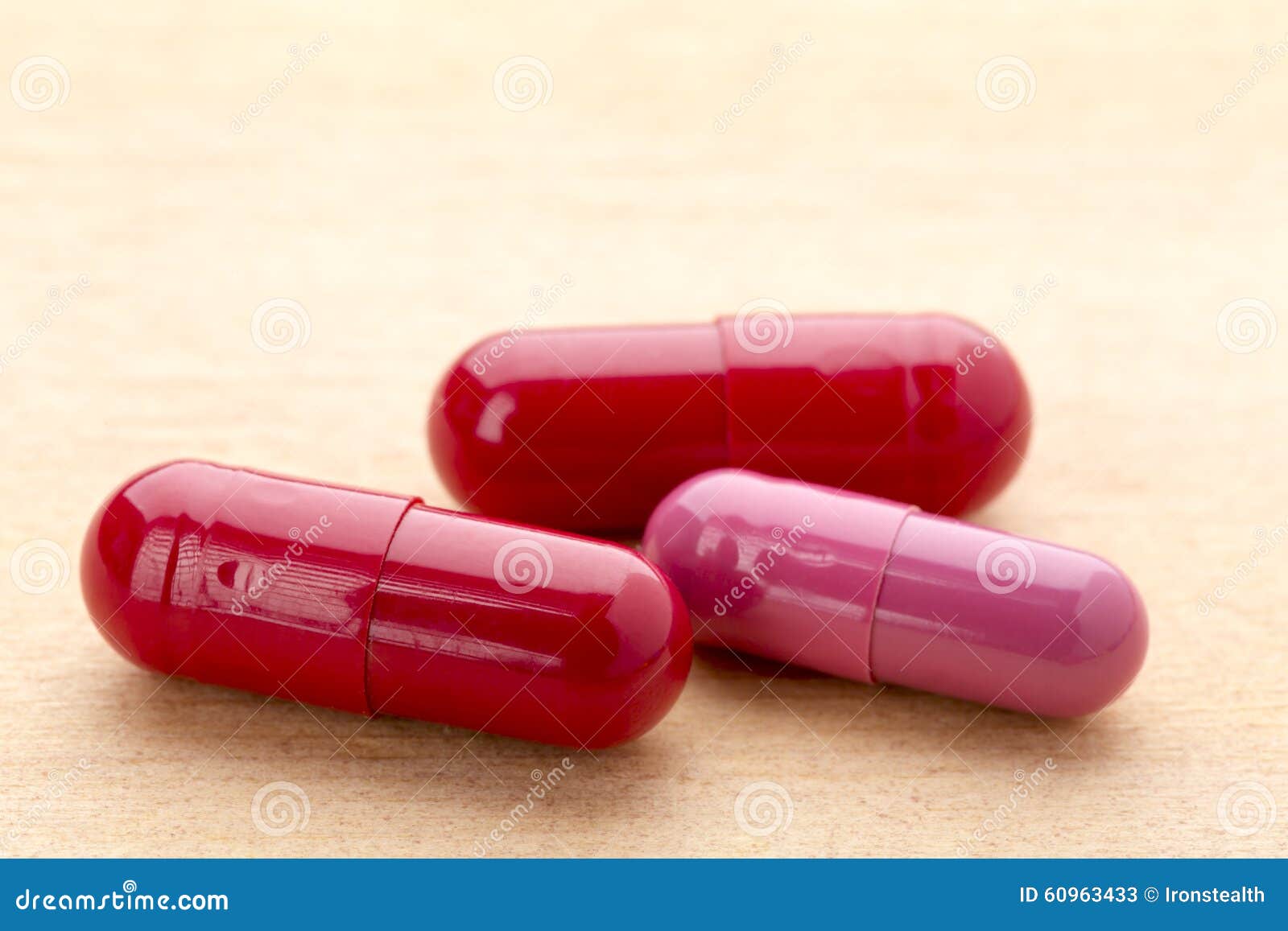 Three Red Capsules on the Wooden Table Stock Image - Image of bright ...