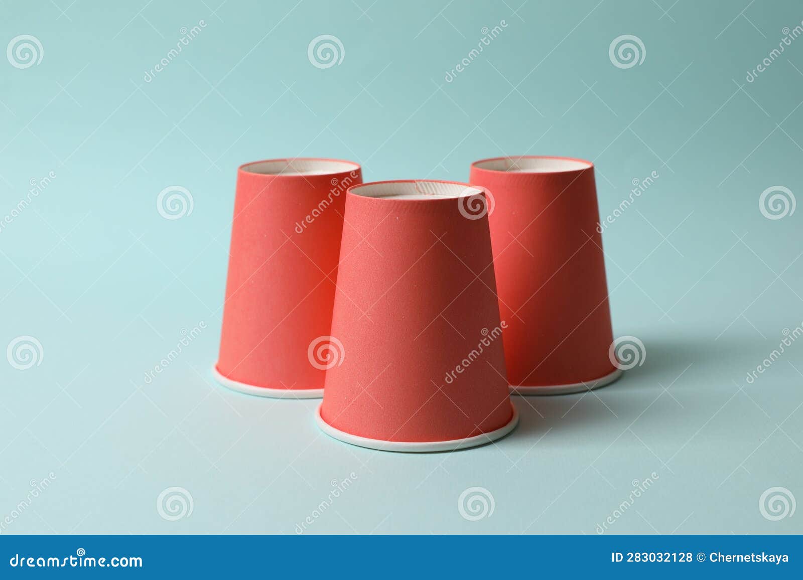 Three Red Cups on Light Blue Background. Thimblerig Game Stock Photo ...