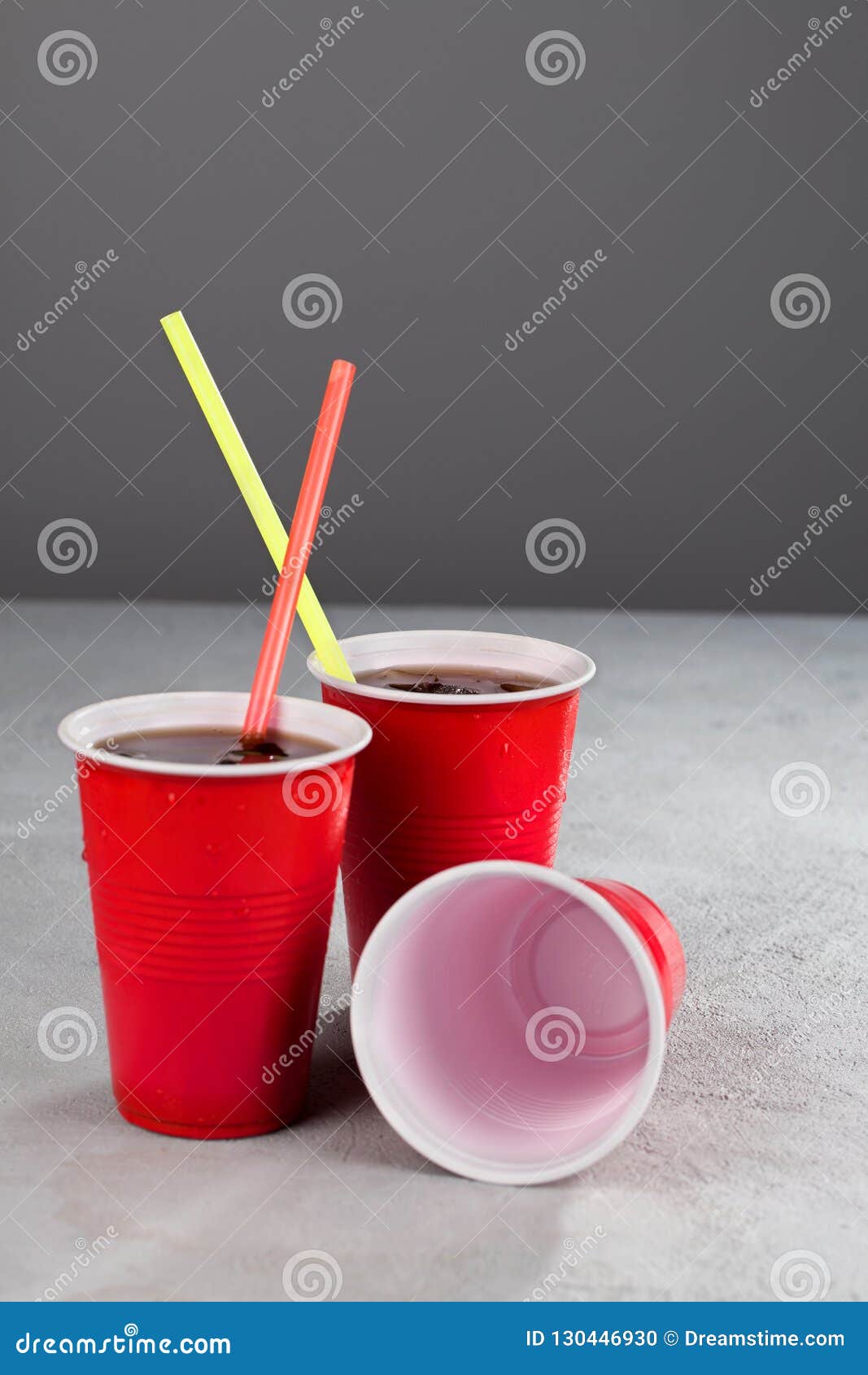Three Red Cups with Soda and Colored Straws on a Gray Background. Two ...