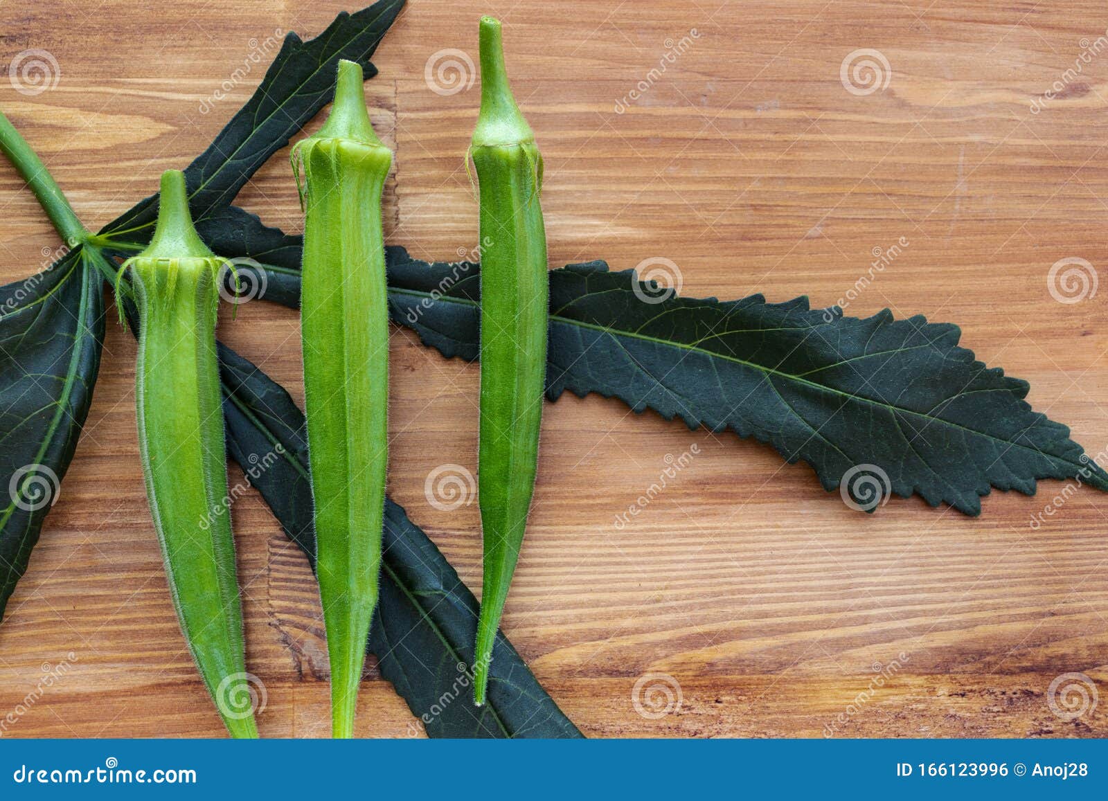 Three Ripe Okras Lie on a Sheet of Okra on a Brown Background Stock ...