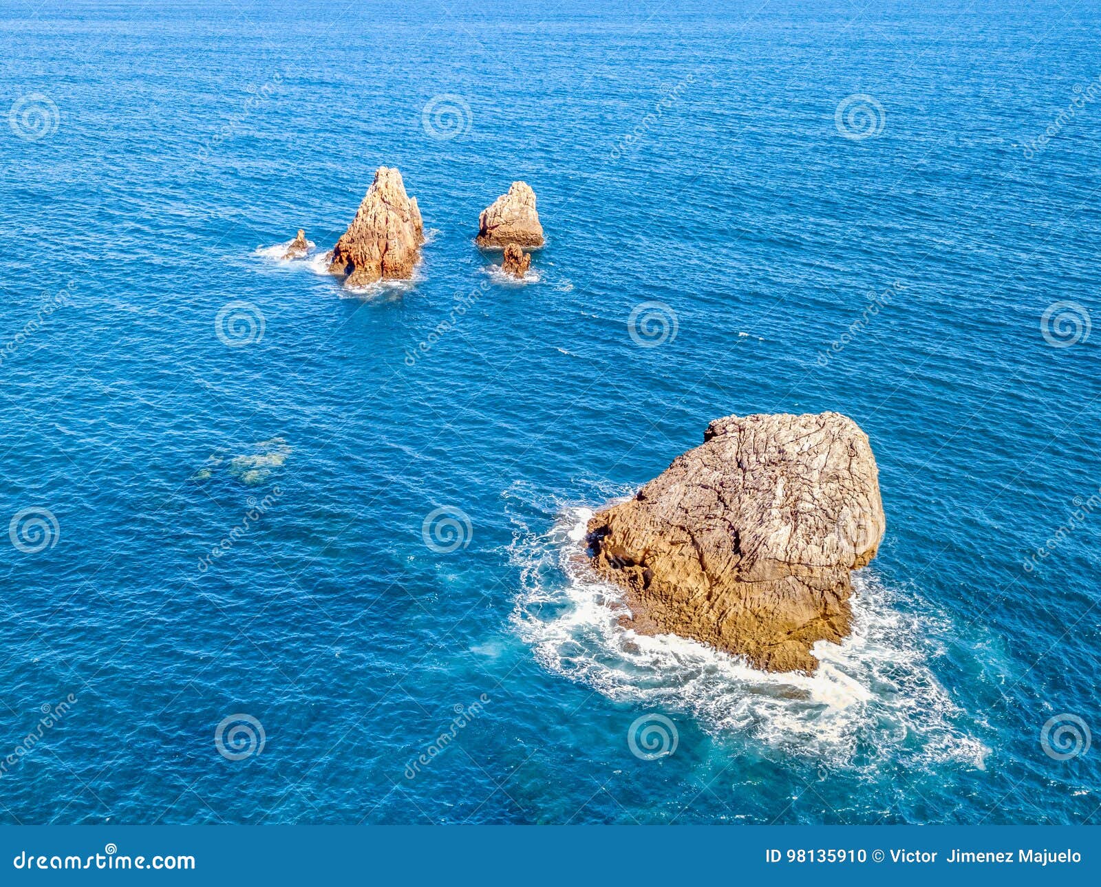Three rocks in the sea stock photo. Image of white, sunlight - 98135910