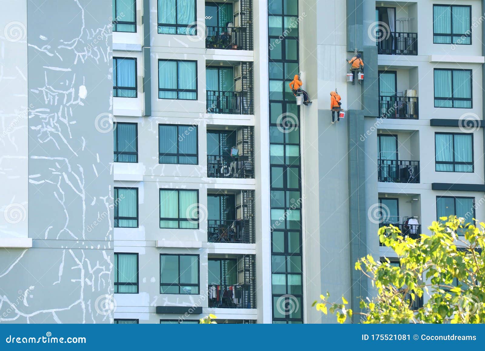 Three Rope Access Workers Painting the Facade of a High Modern Building ...