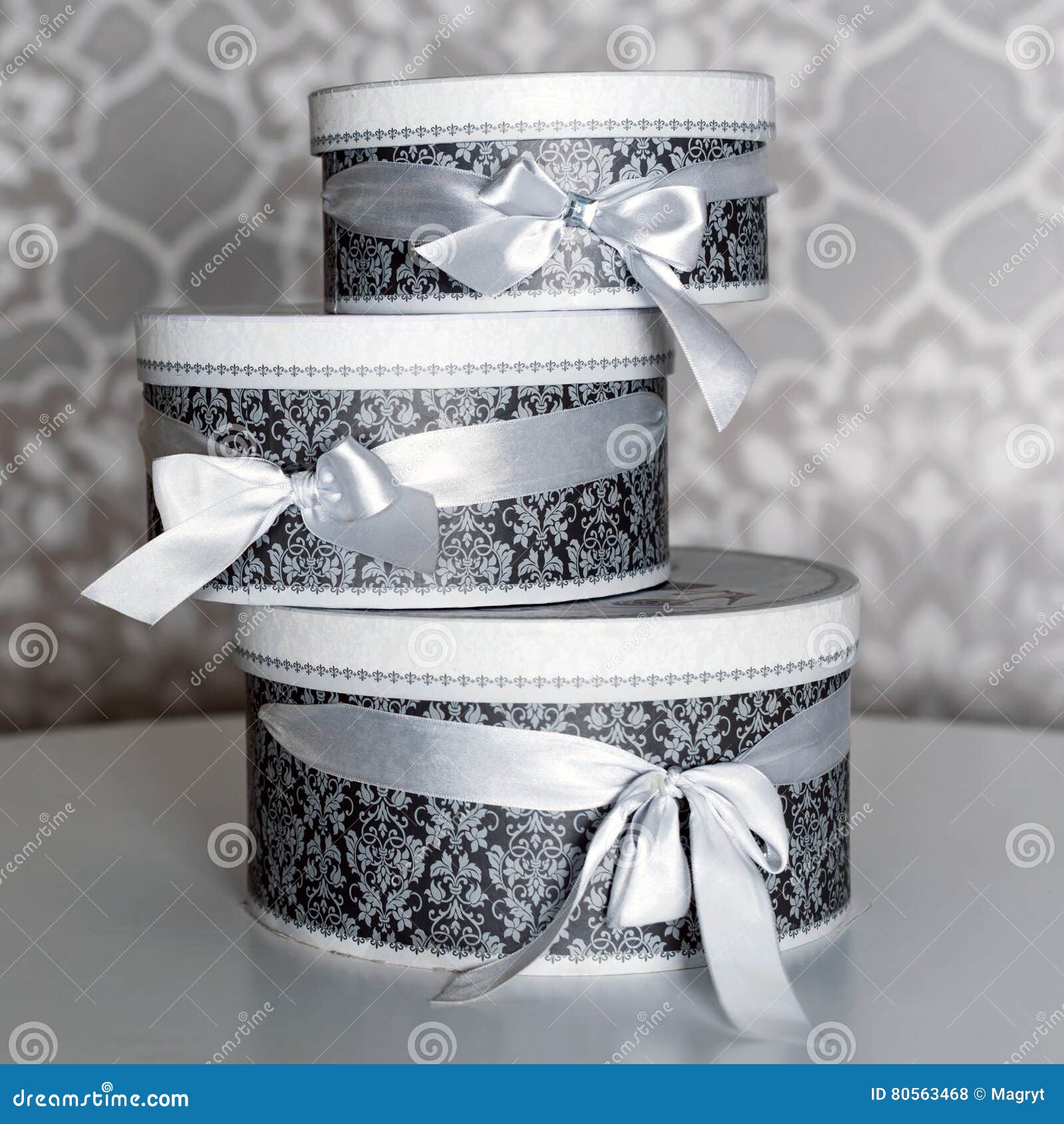 Three Round Celebration Gift Boxes with Silver Ribbon Bows on White ...